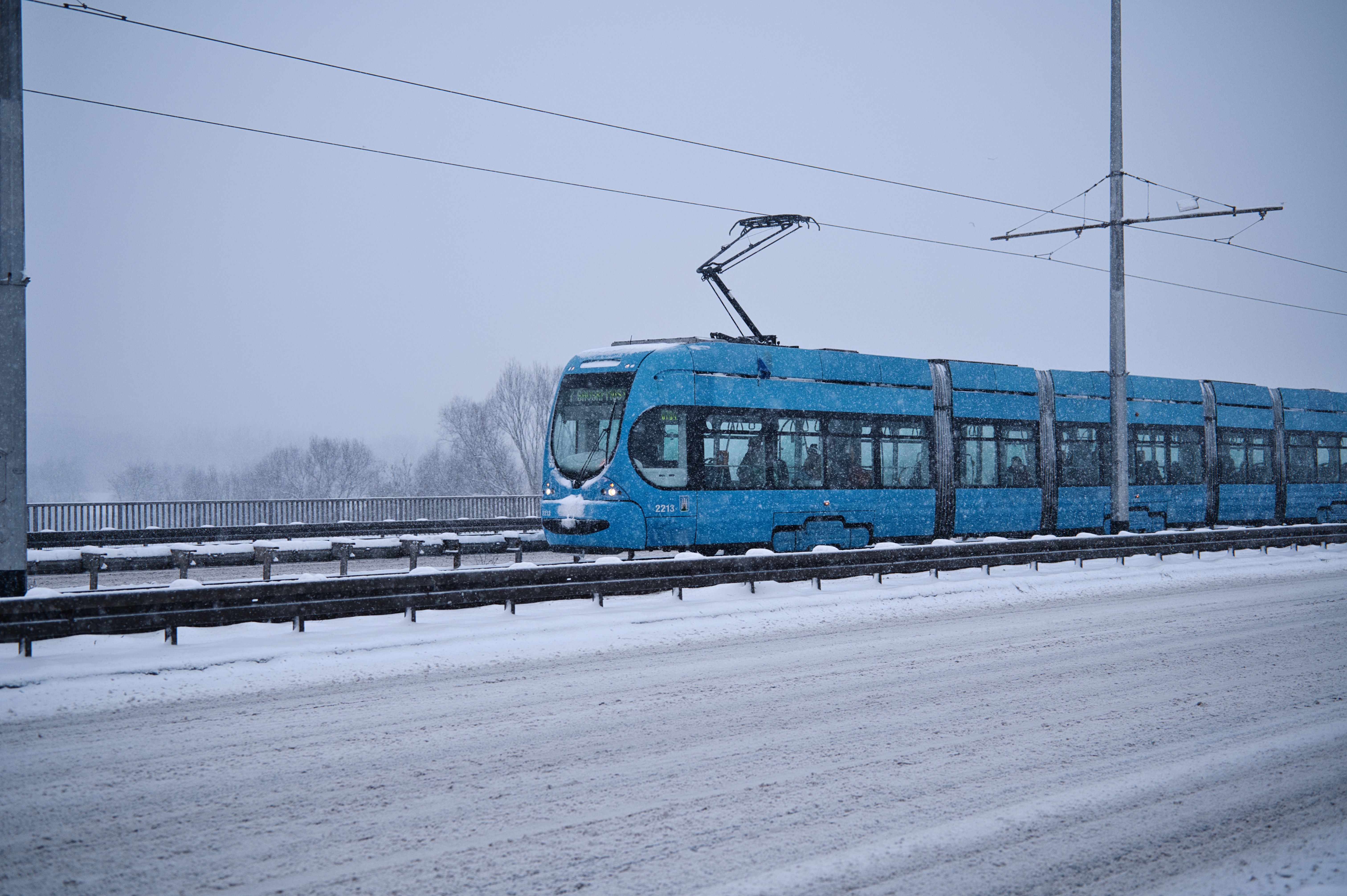Blue tram in snowy urban winter scene · Free Stock Photo