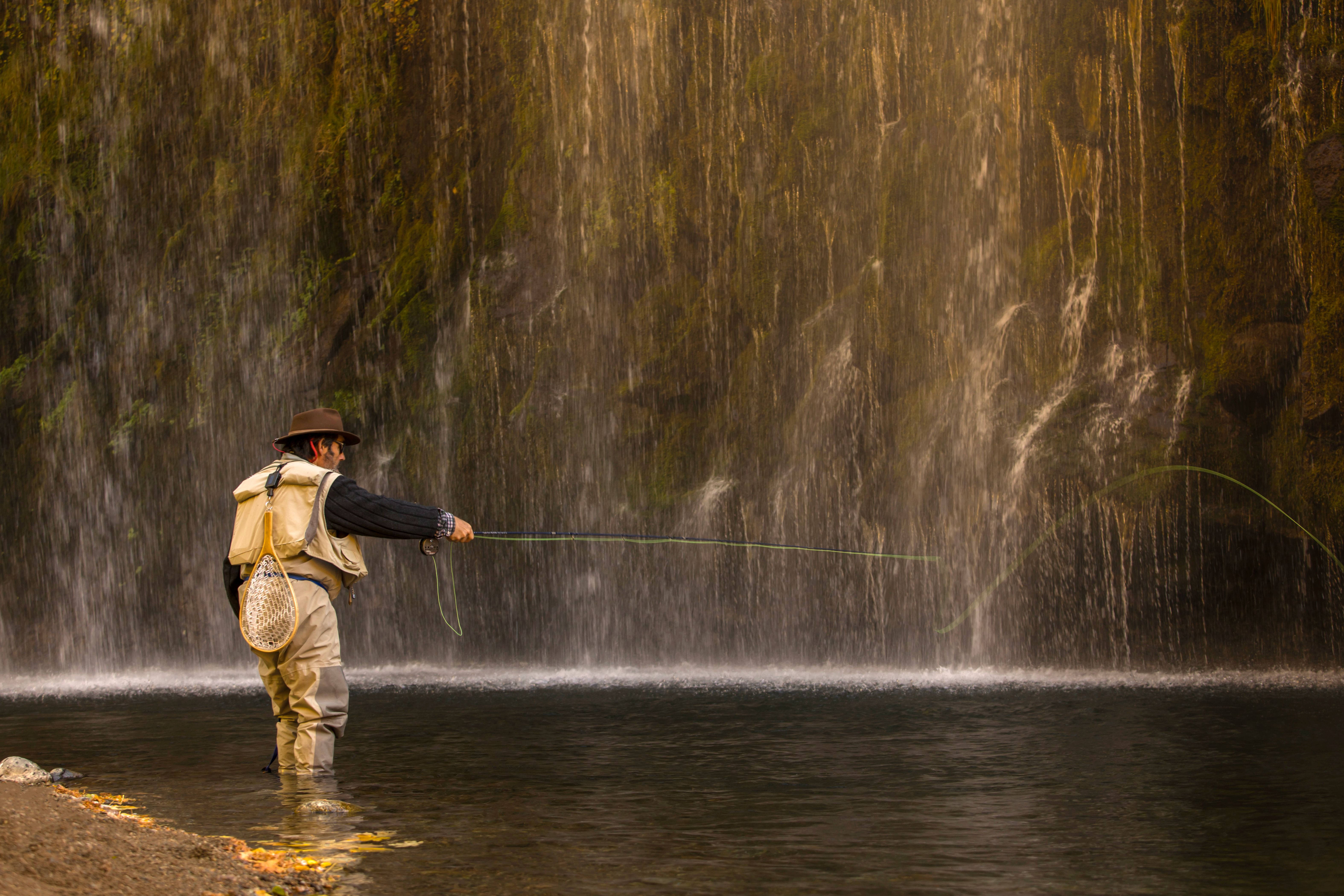 Man Fly Fishing in Scenic Waterfall Setting · Free Stock Photo
