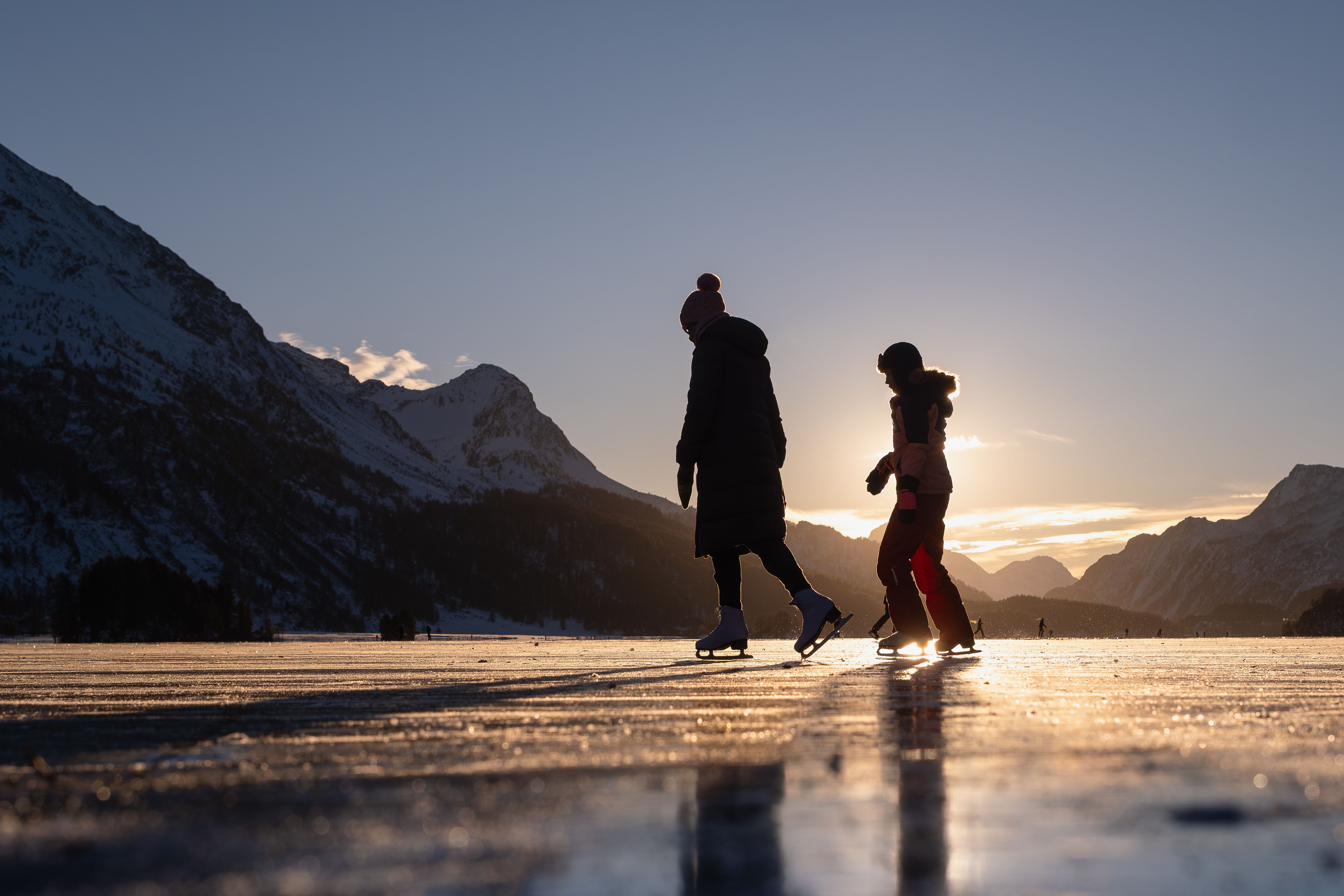 Silhouette of Ice Skating at Sunset in Alpine Scenery · Free Stock Photo