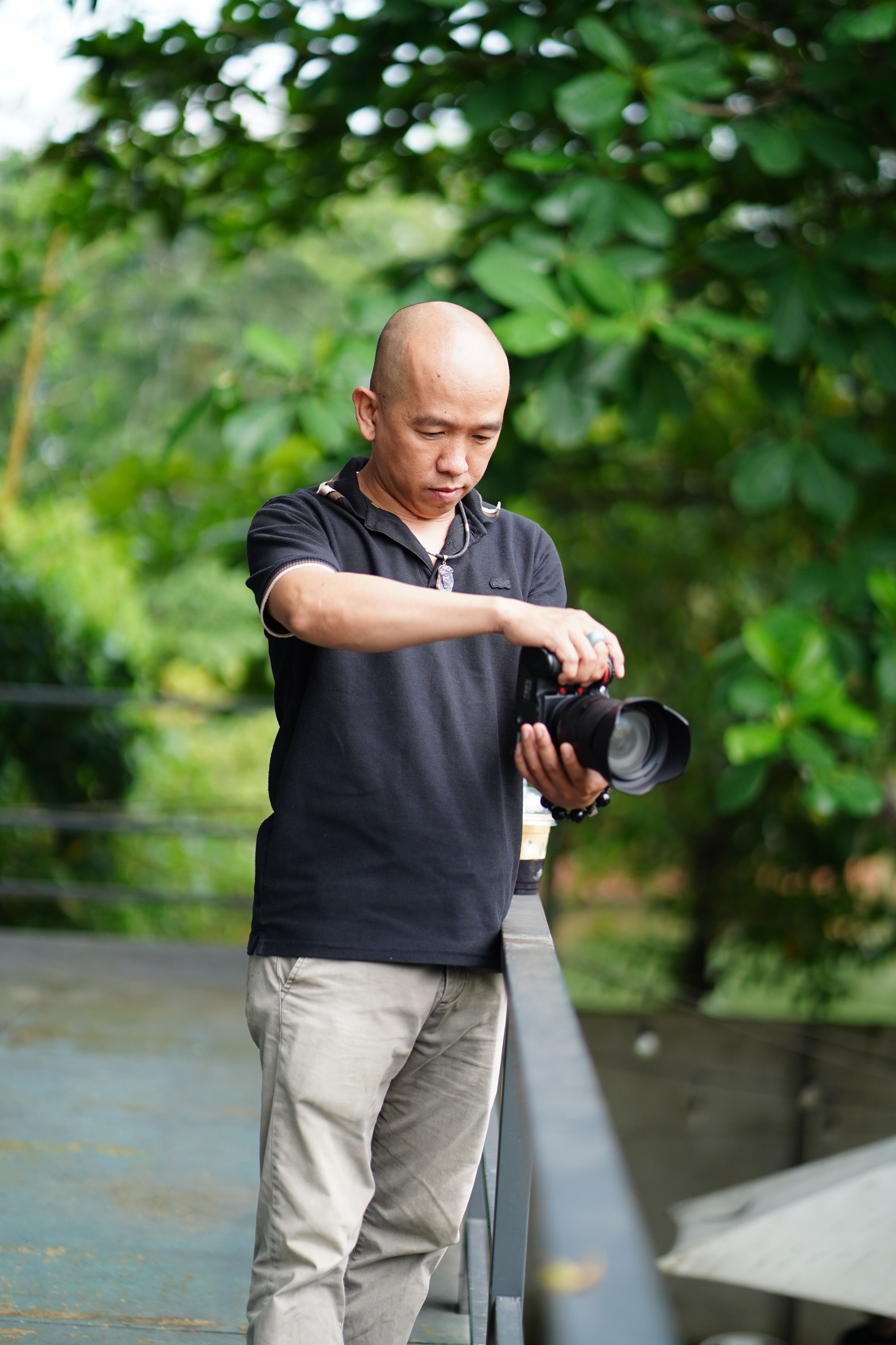 Photographer Adjusting Camera in Nature Setting · Free Stock Photo