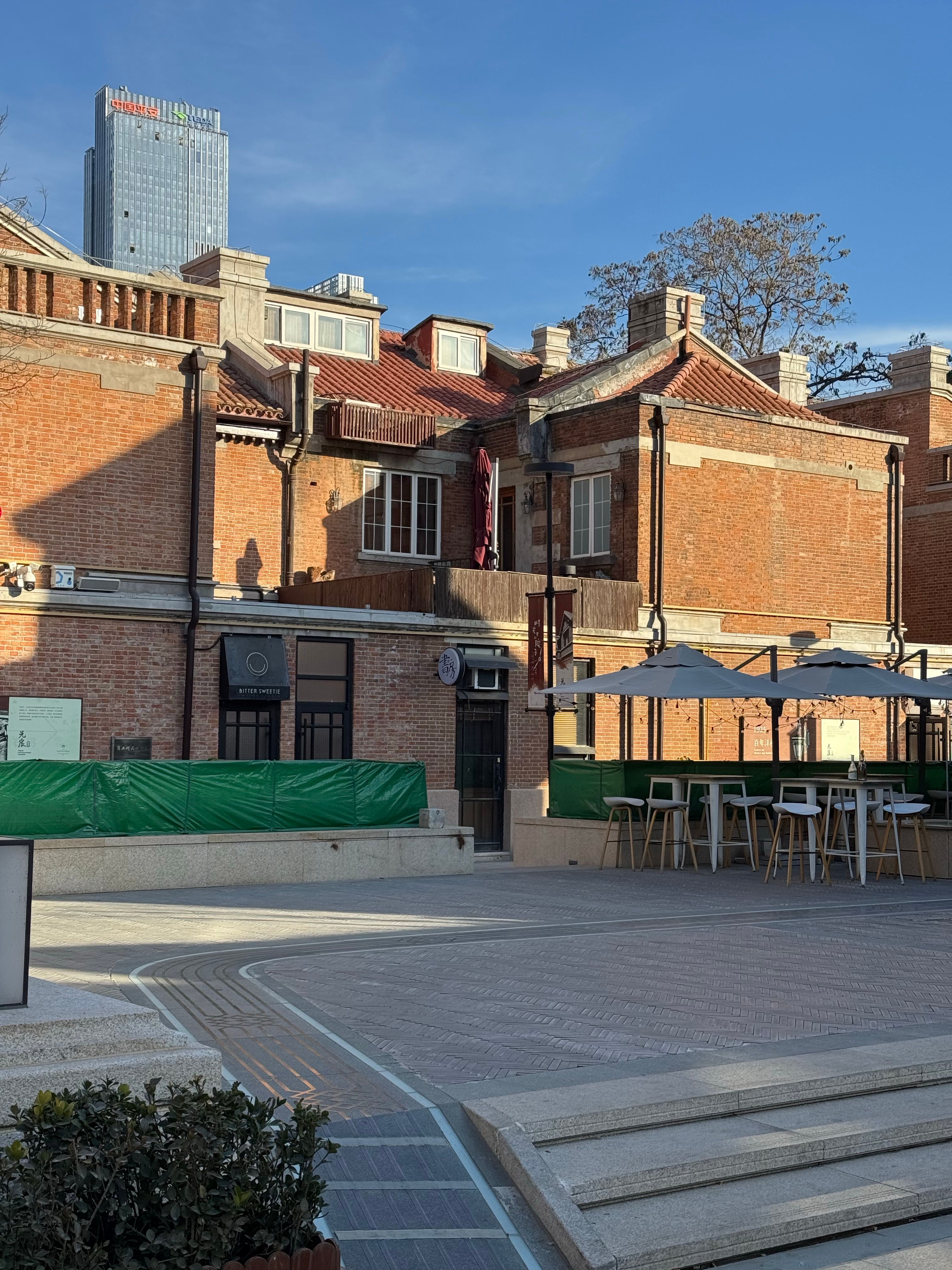 Historic Brick Building with Outdoor Cafe Seating · Free Stock Photo