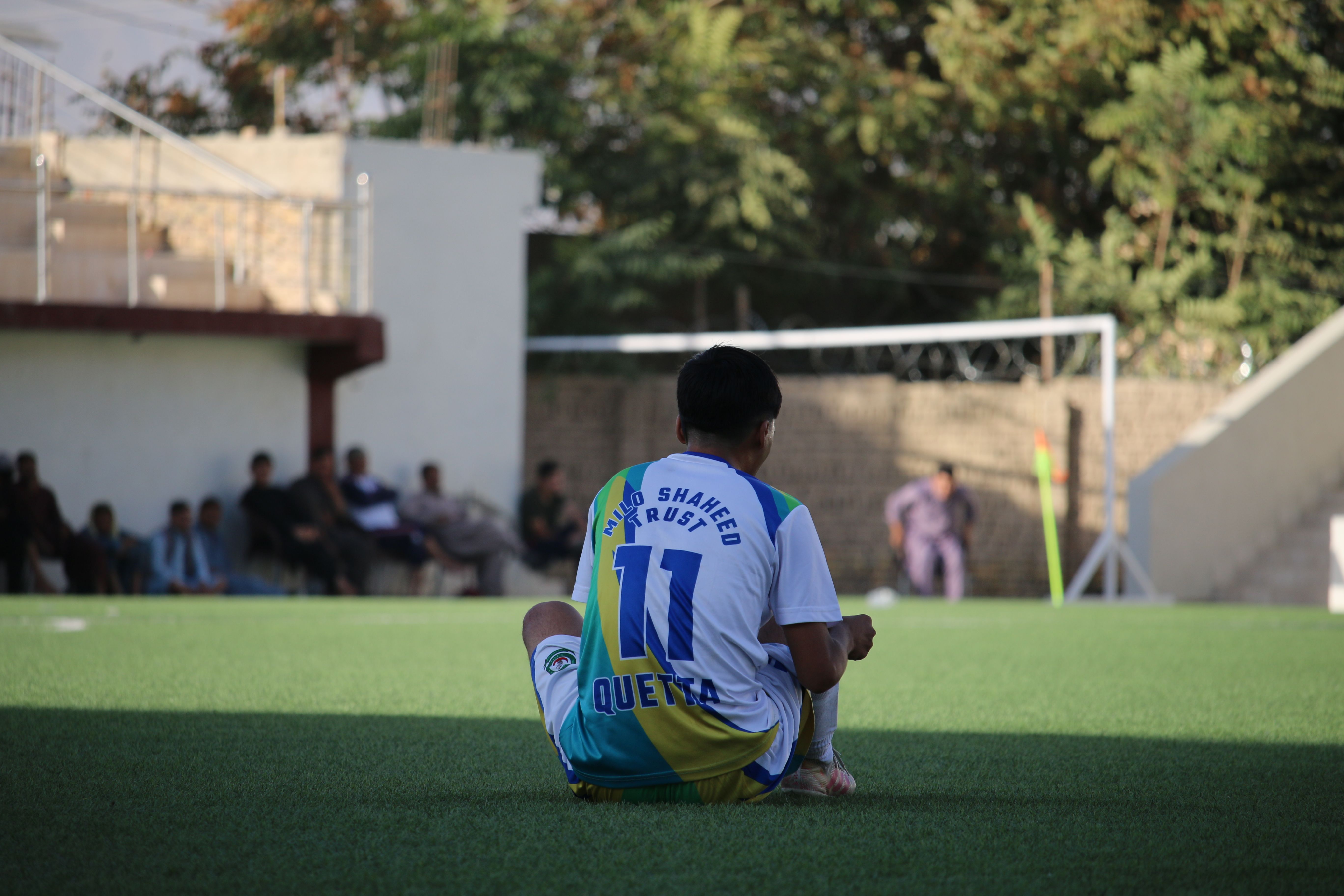 Young Soccer Player Resting on the Field · Free Stock Photo