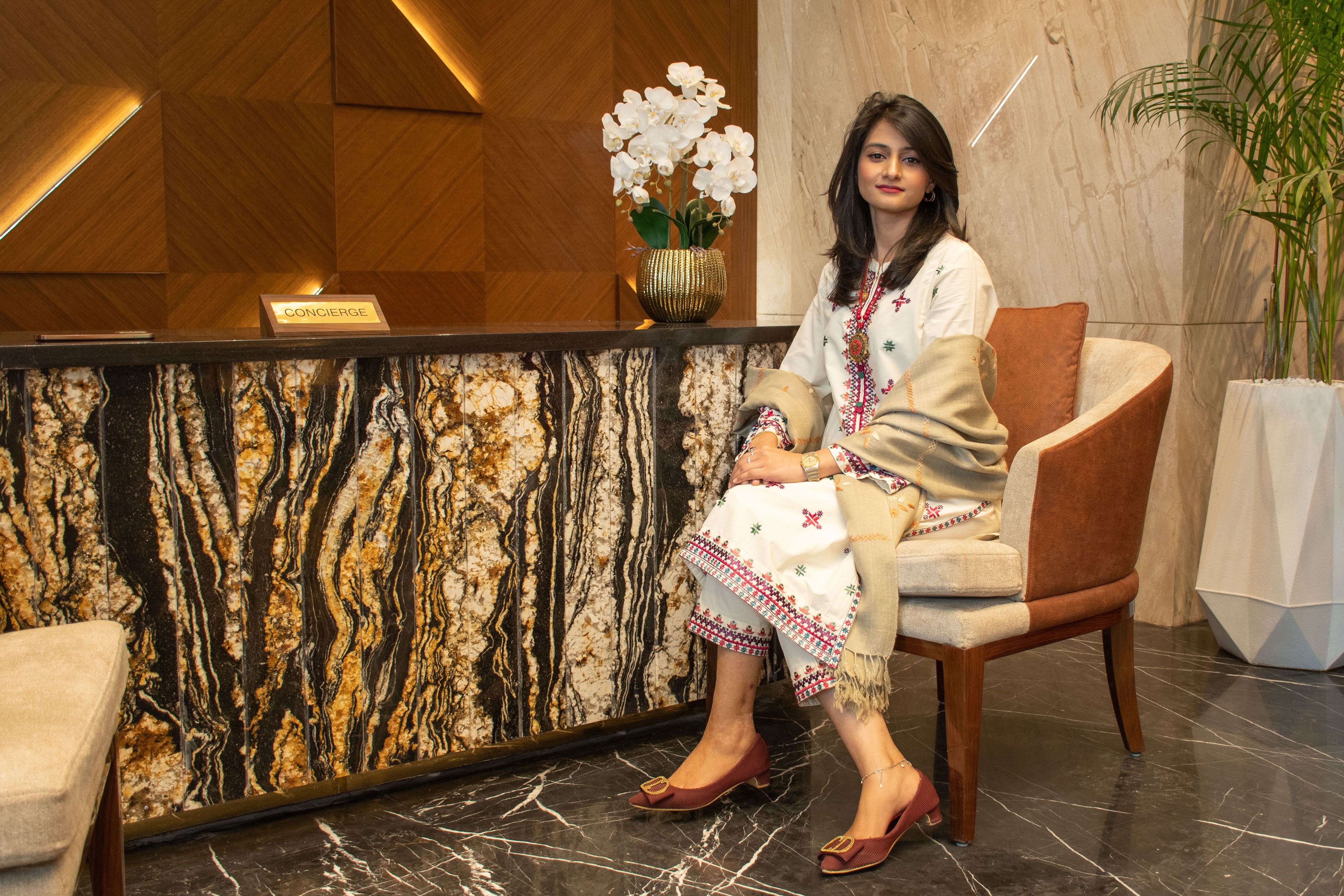 Elegant Woman Sitting at Luxurious Concierge Desk · Free Stock Photo