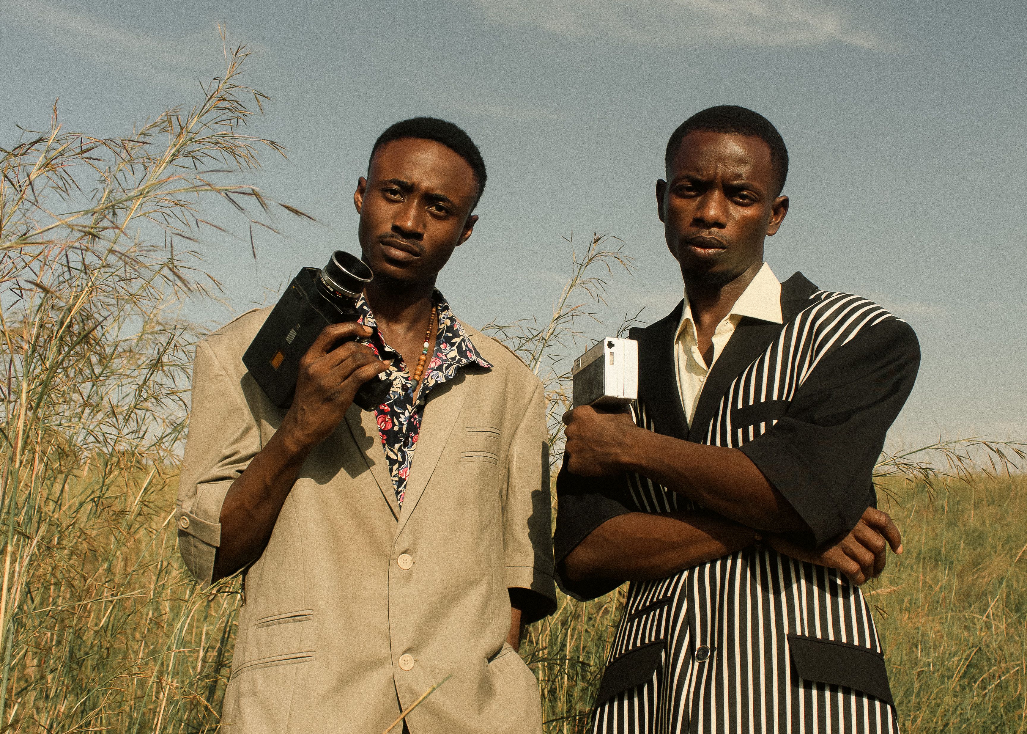 Stylish Portrait of Two Men with Cameras Outdoors · Free Stock Photo