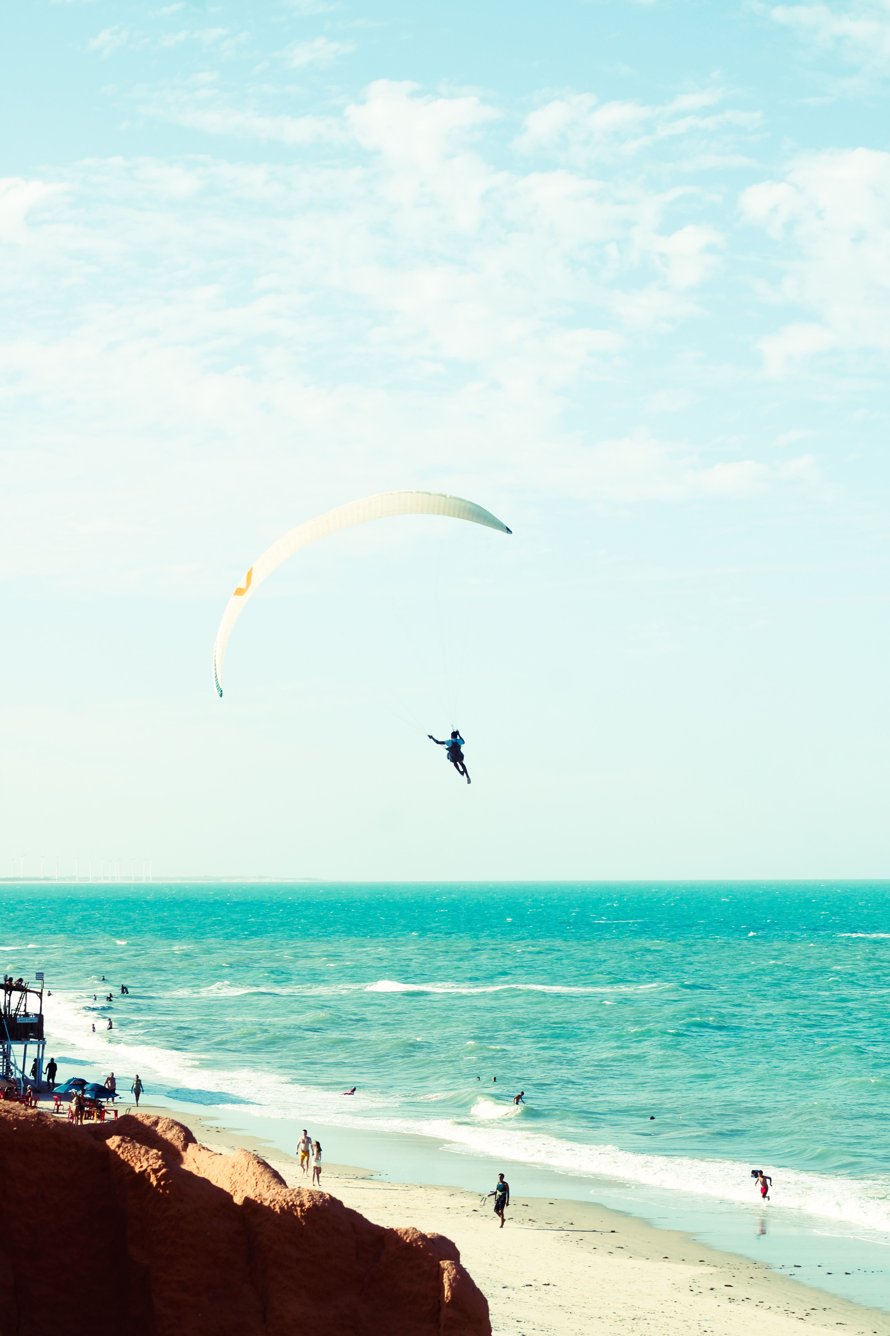 Paraglider Soaring Over Scenic Coastal Cliffs · Free Stock Photo