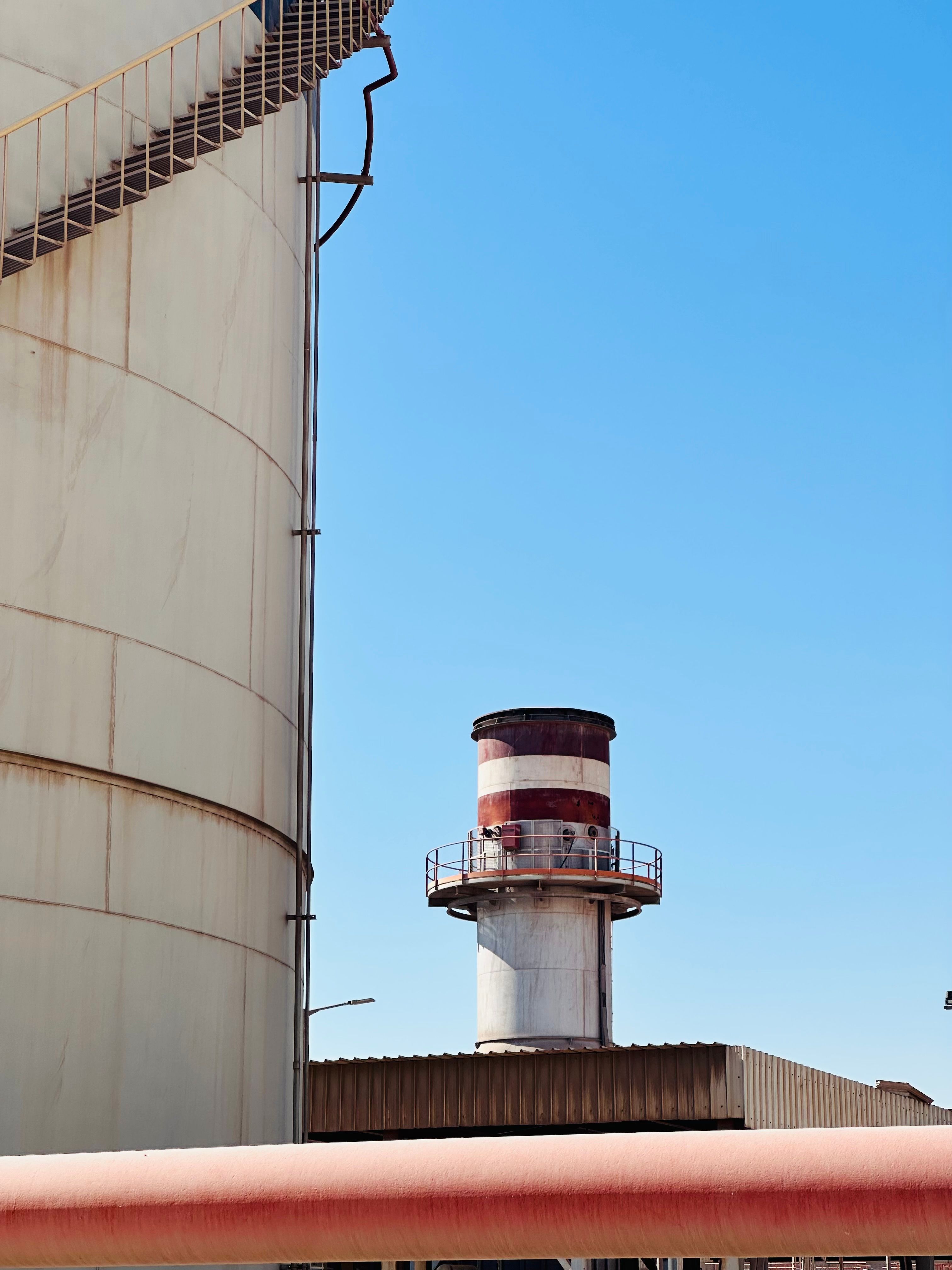 Industrial Storage Tanks Against Clear Blue Sky · Free Stock Photo