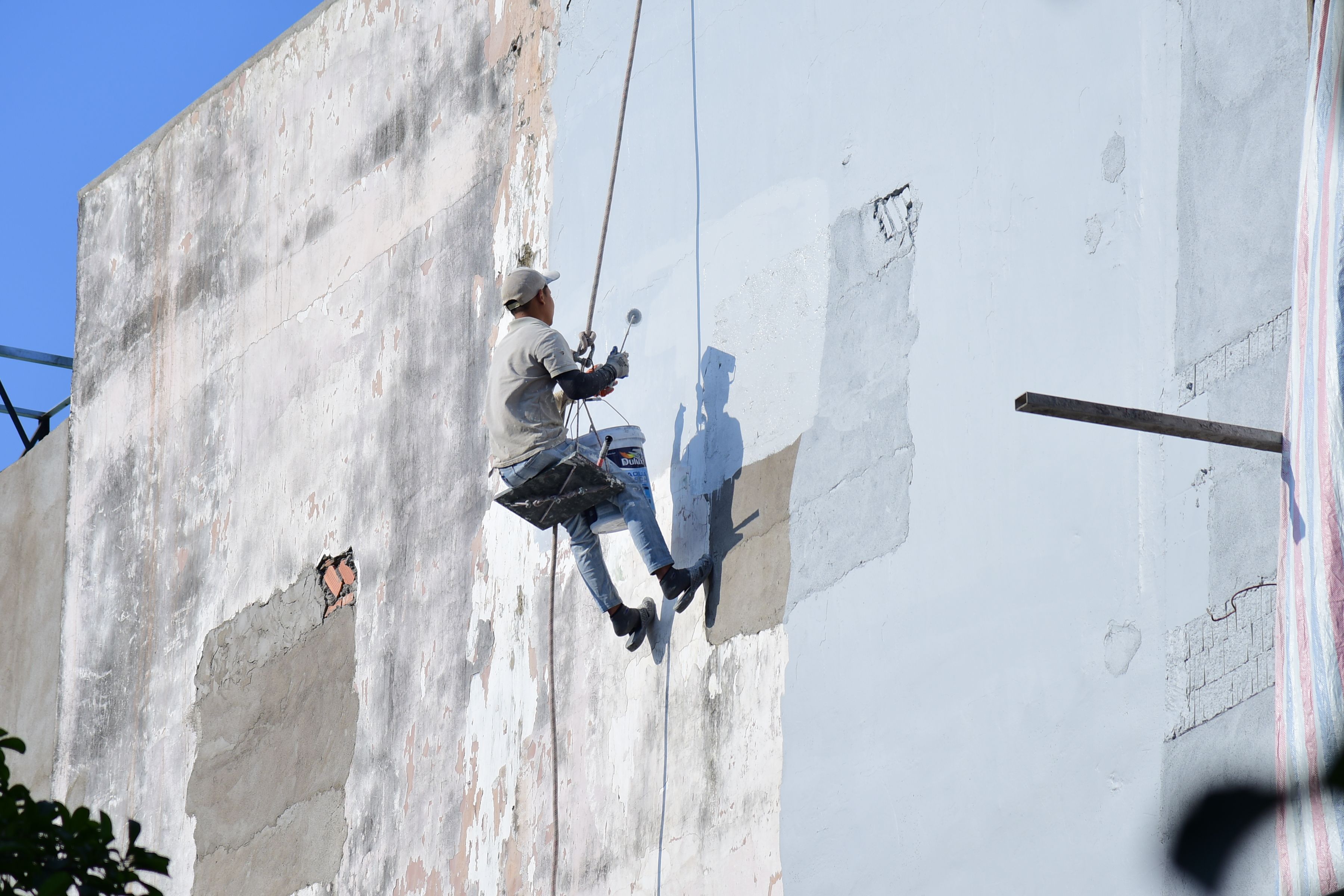 Rope Access Worker Painting High-rise Building Exterior · Free Stock Photo