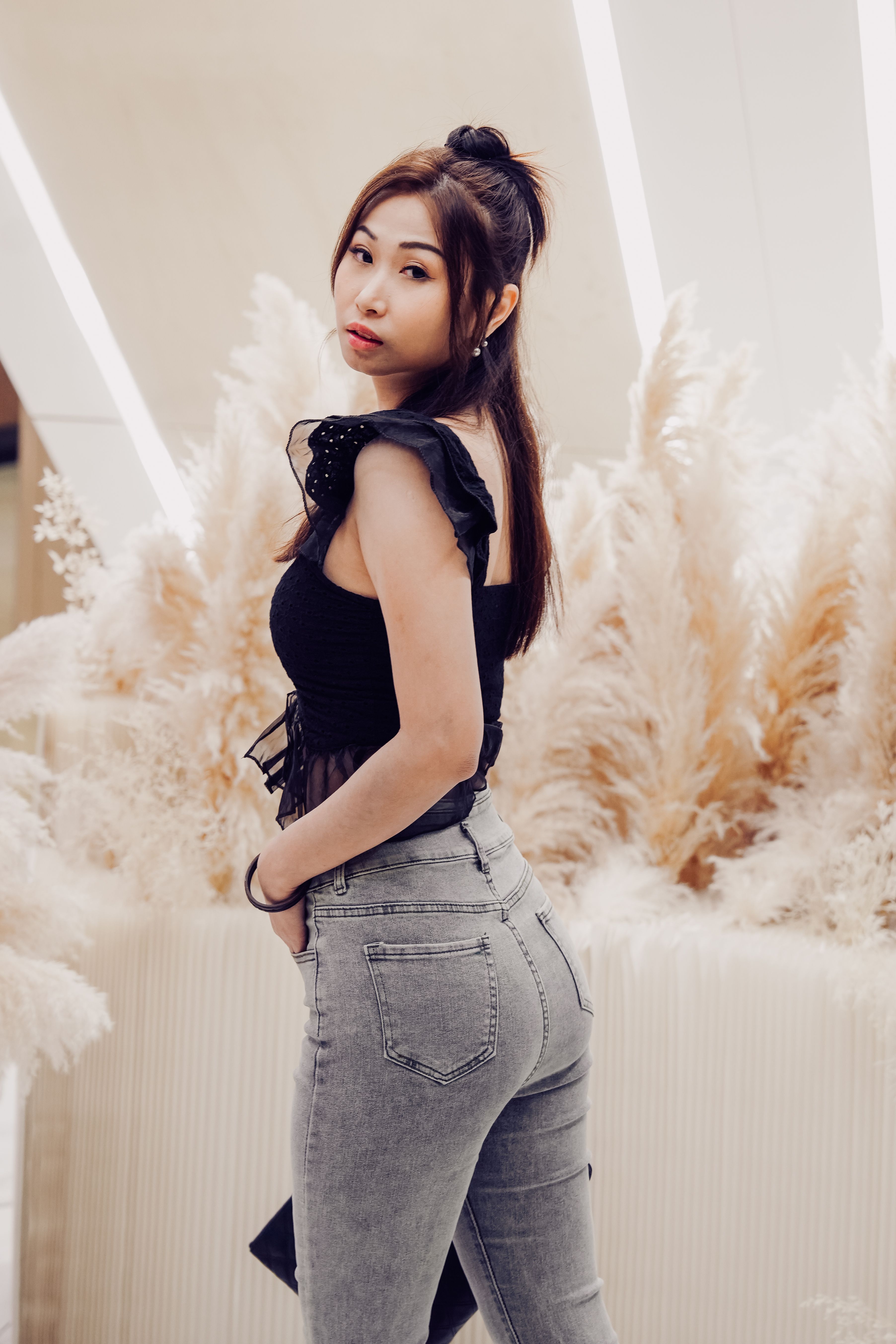 Elegant Woman Posing Indoors with Pampas Grass · Free Stock Photo