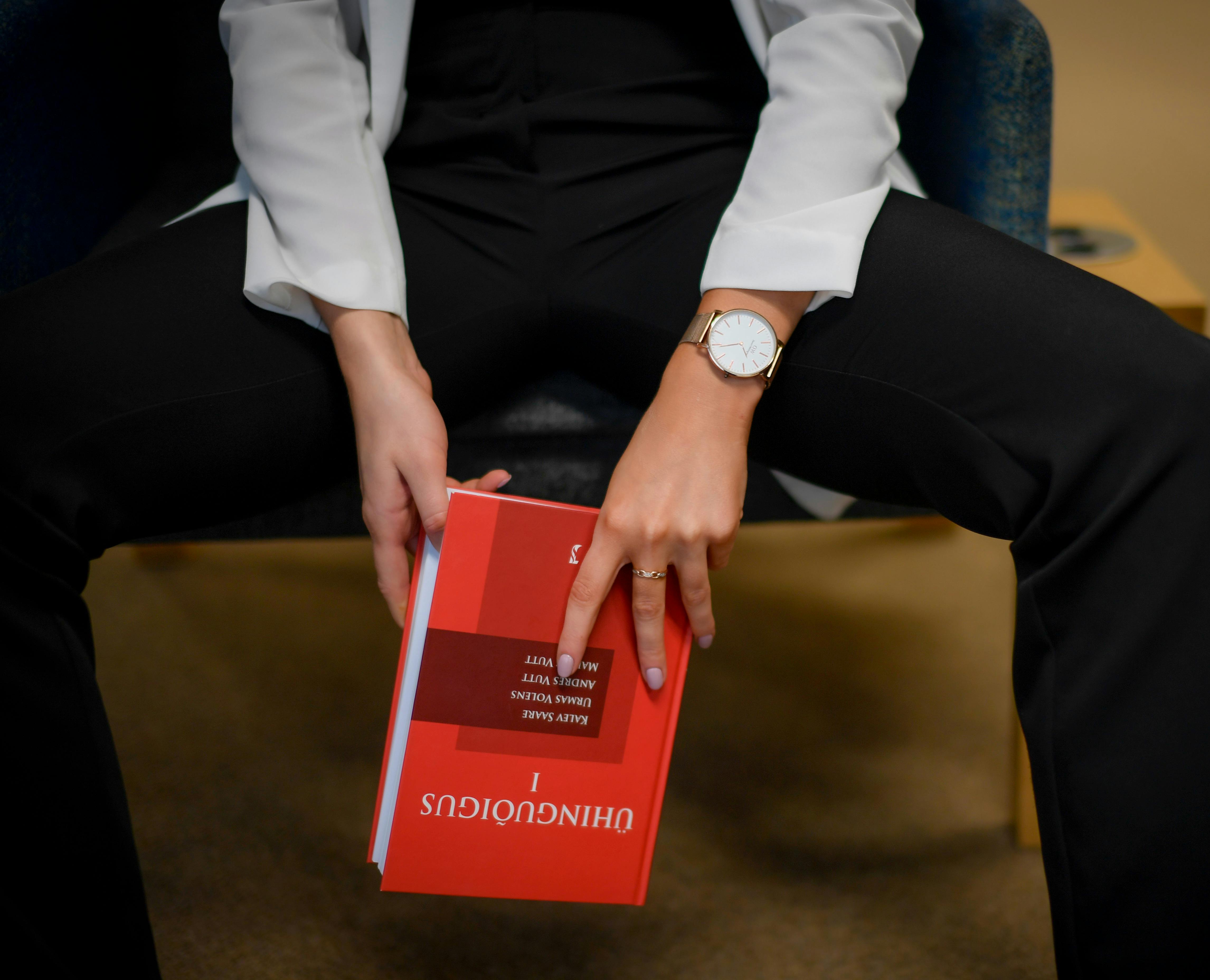 Woman Holding Red Book in a Modern Library Setting · Free Stock Photo