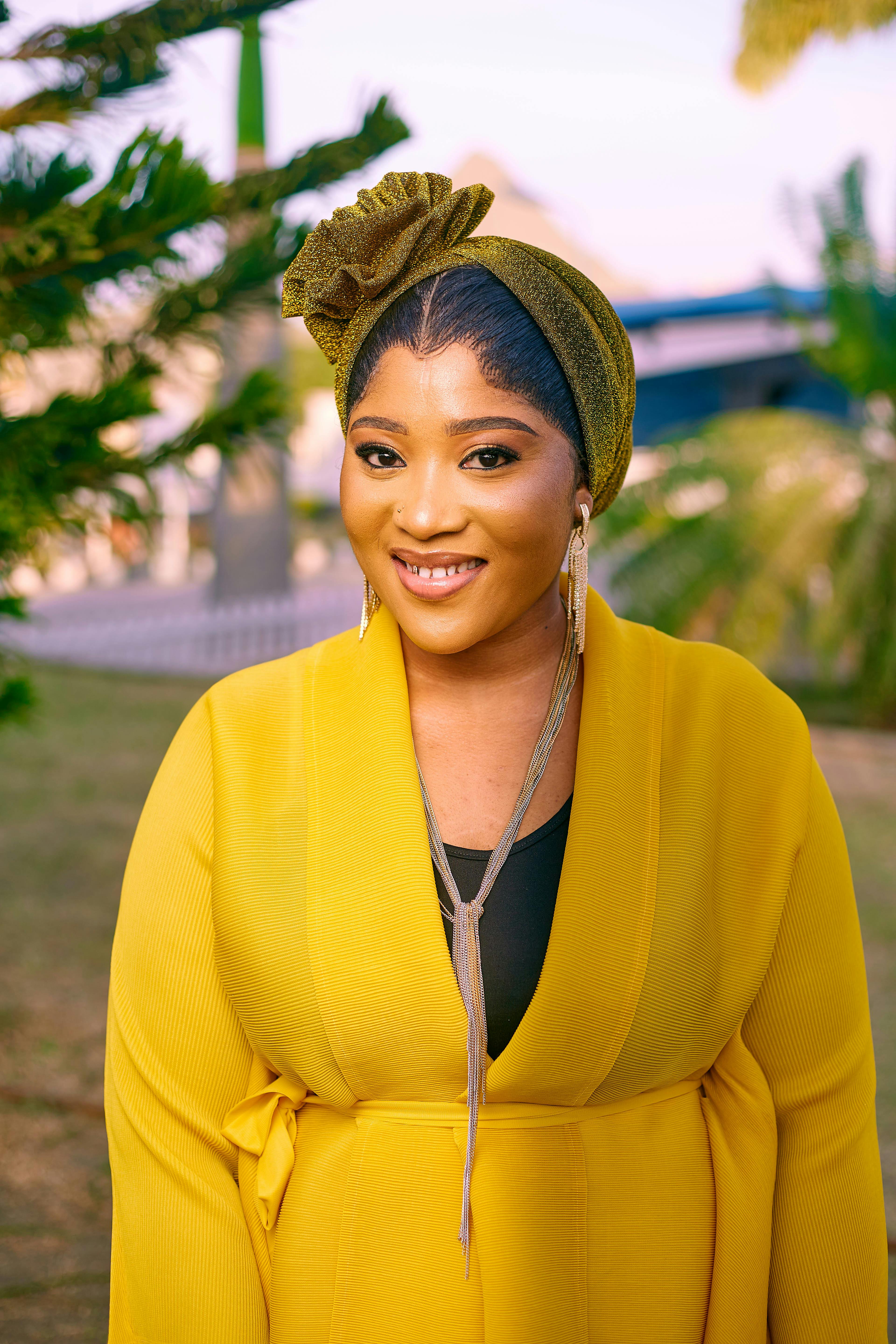 Smiling Woman in Bright Yellow Outfit Outdoors · Free Stock Photo