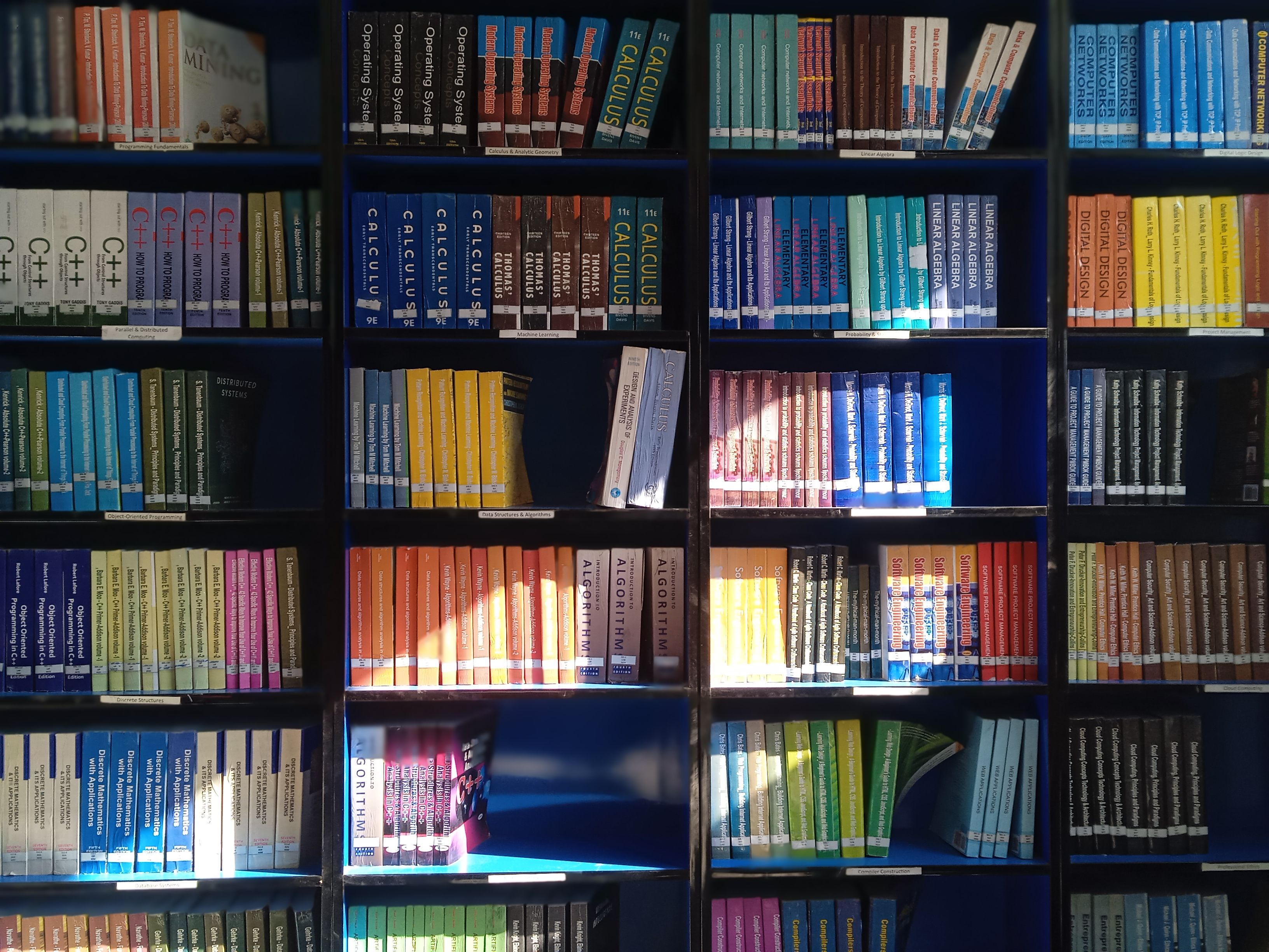 Colorful Library Bookshelf with Diverse Subjects · Free Stock Photo