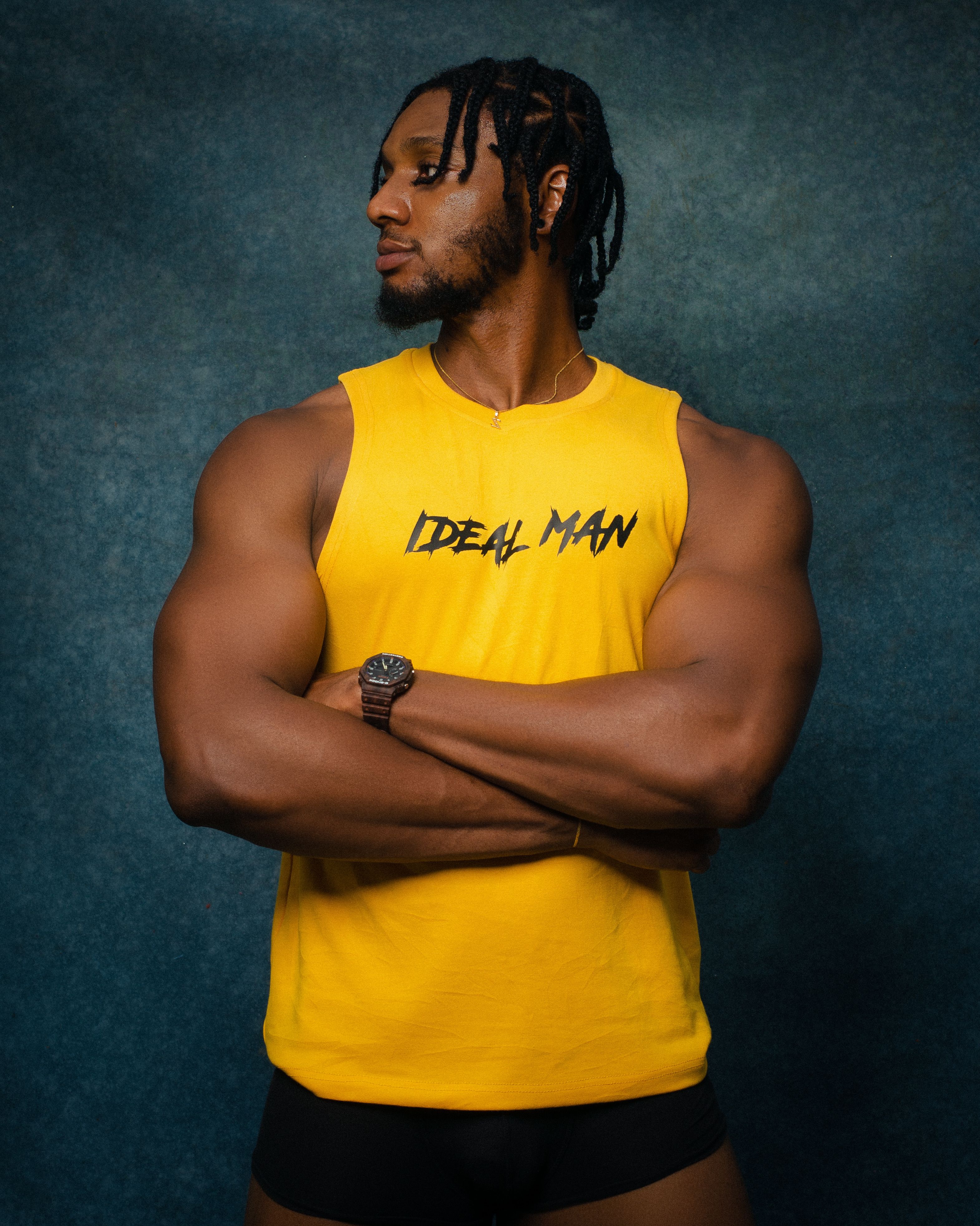 Strong Male Model in Yellow Tank Top Posing Confidently · Free Stock Photo