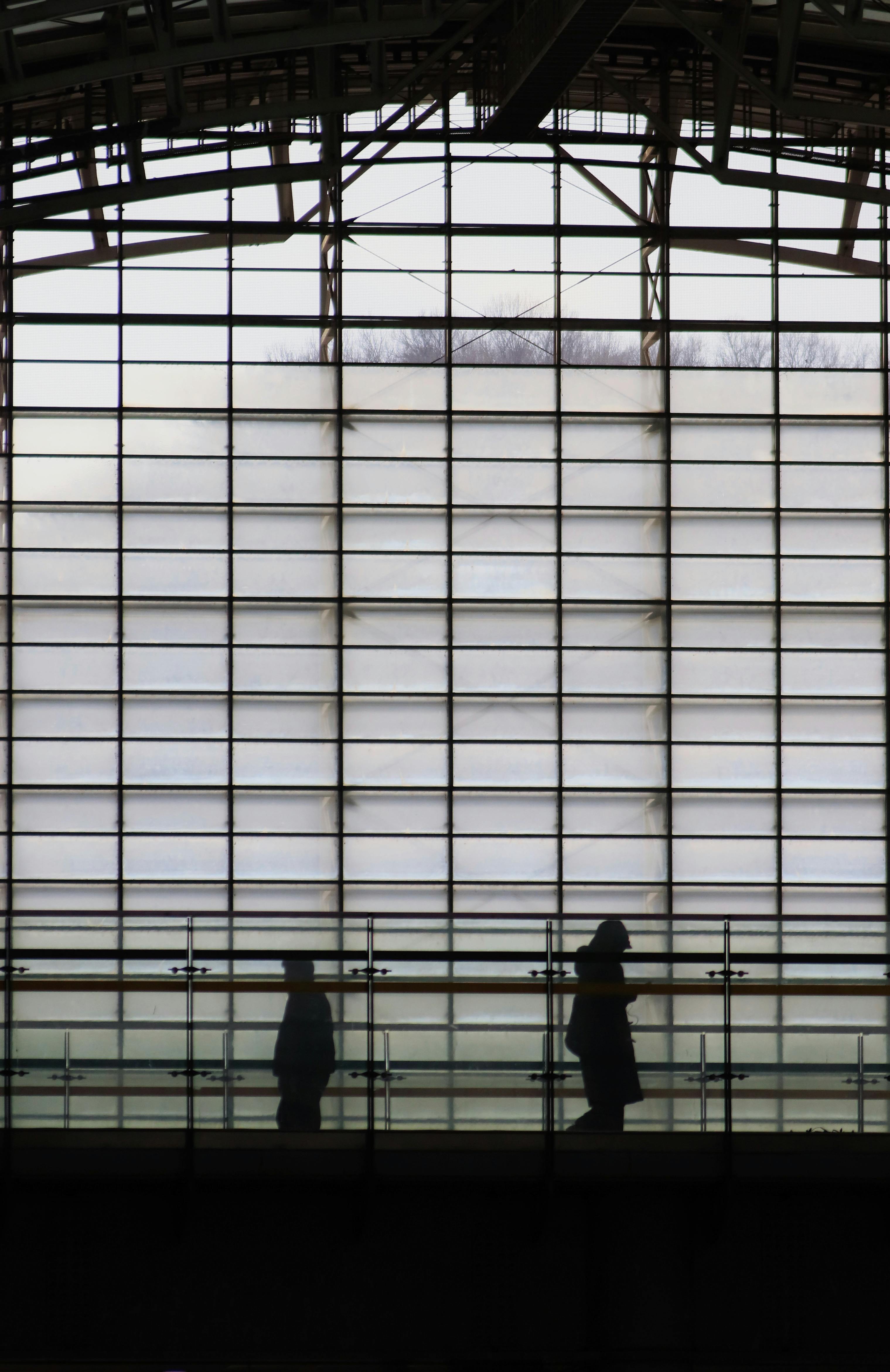 Silhouetted Figures in Modern Train Station · Free Stock Photo