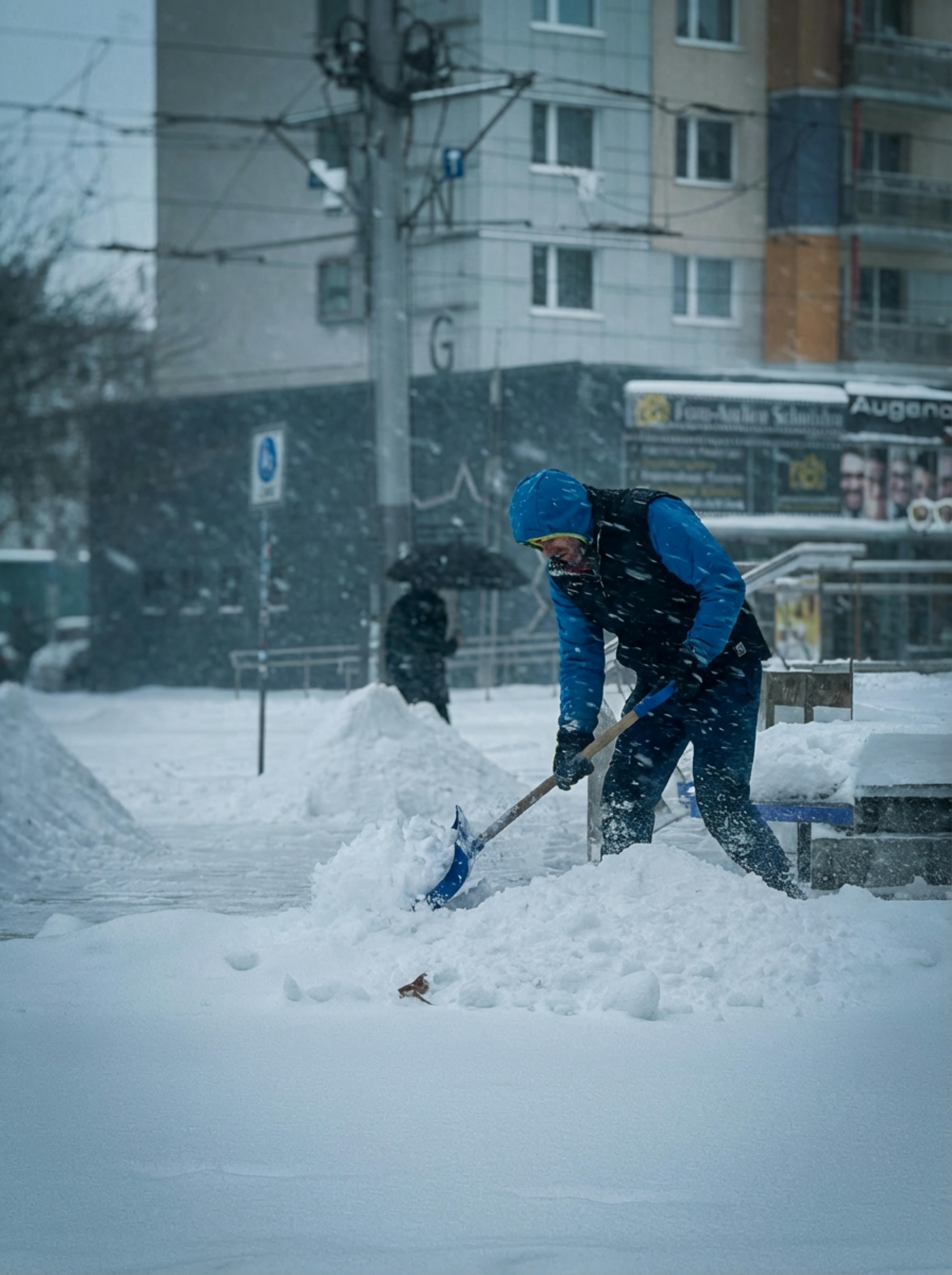 Person Shoveling Snow on Winter Urban Street · Free Stock Photo