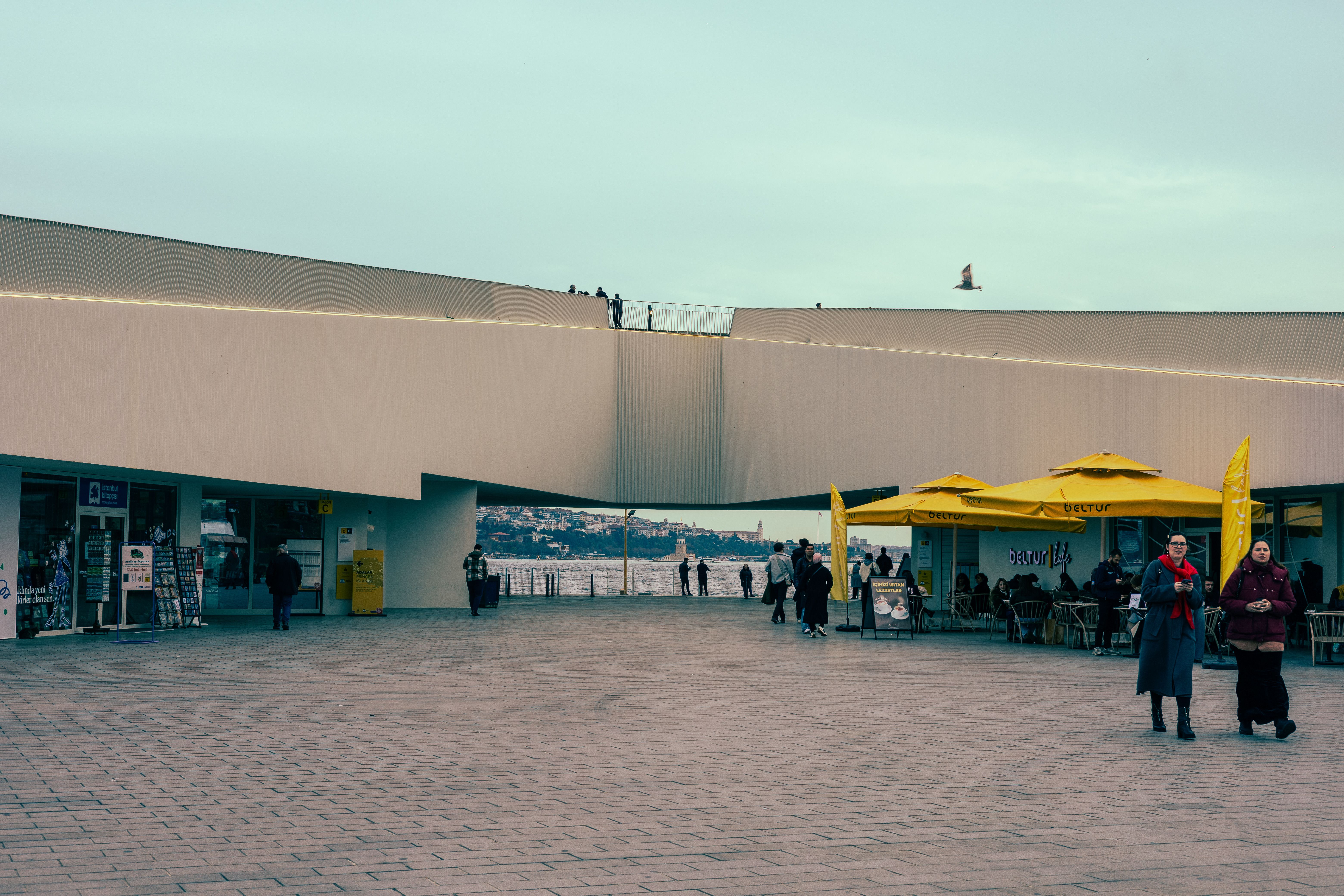 Modern Waterfront Structure with People Walking · Free Stock Photo
