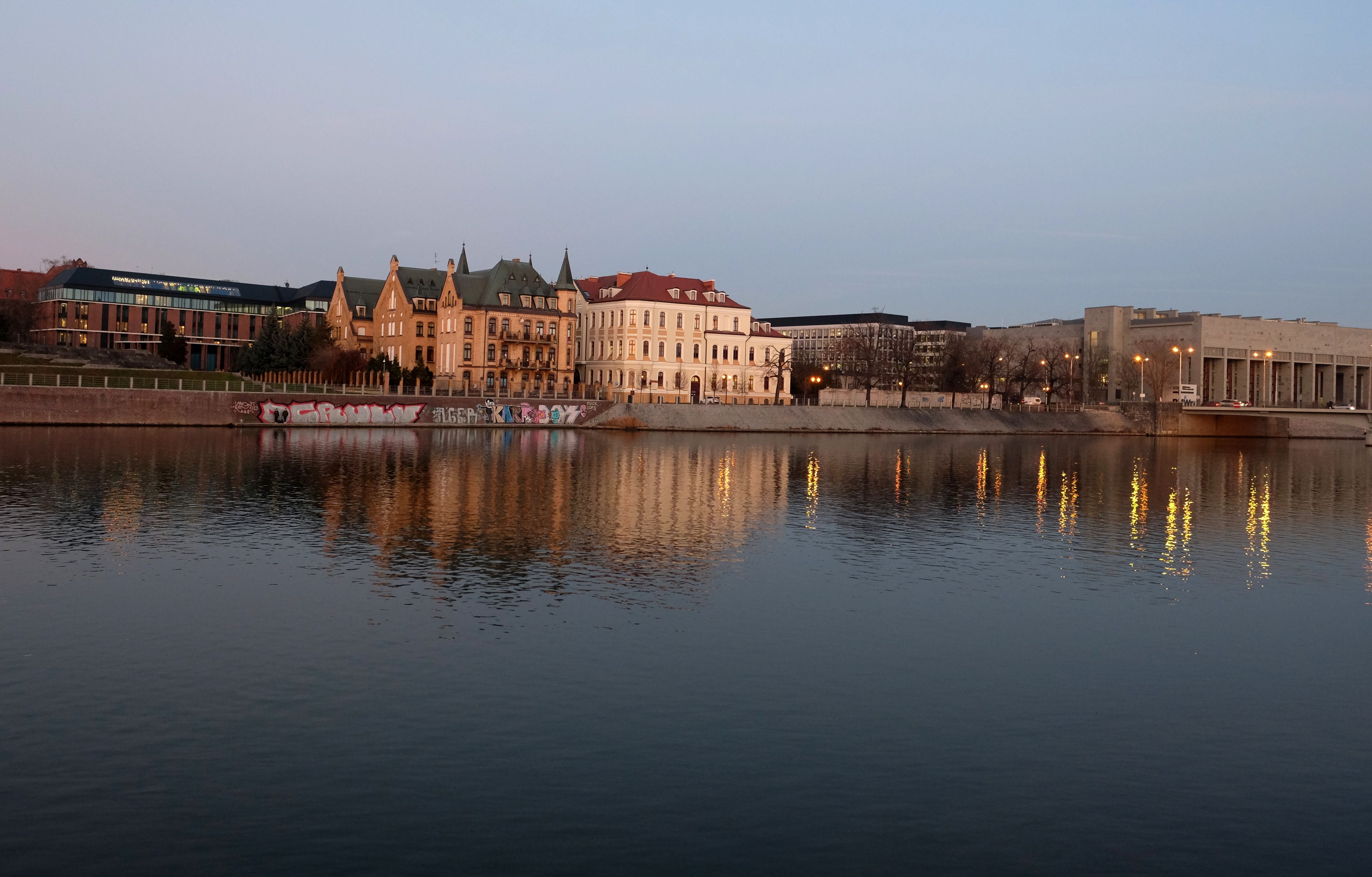 Scenic Riverside View of Historic Buildings at Dusk · Free Stock Photo