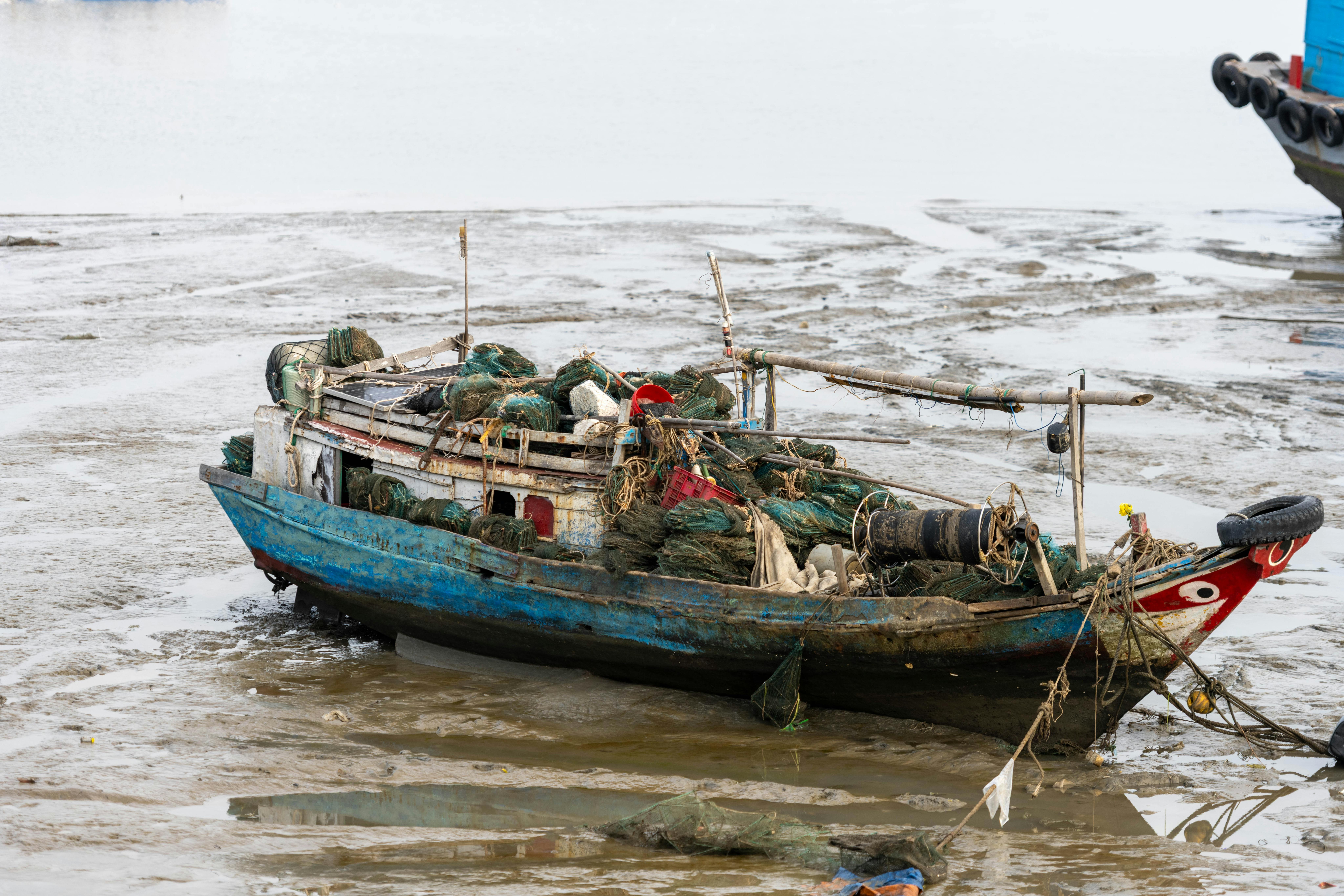 Traditional Fishing Boat on Muddy Shore in Vũng Tàu · Free Stock Photo