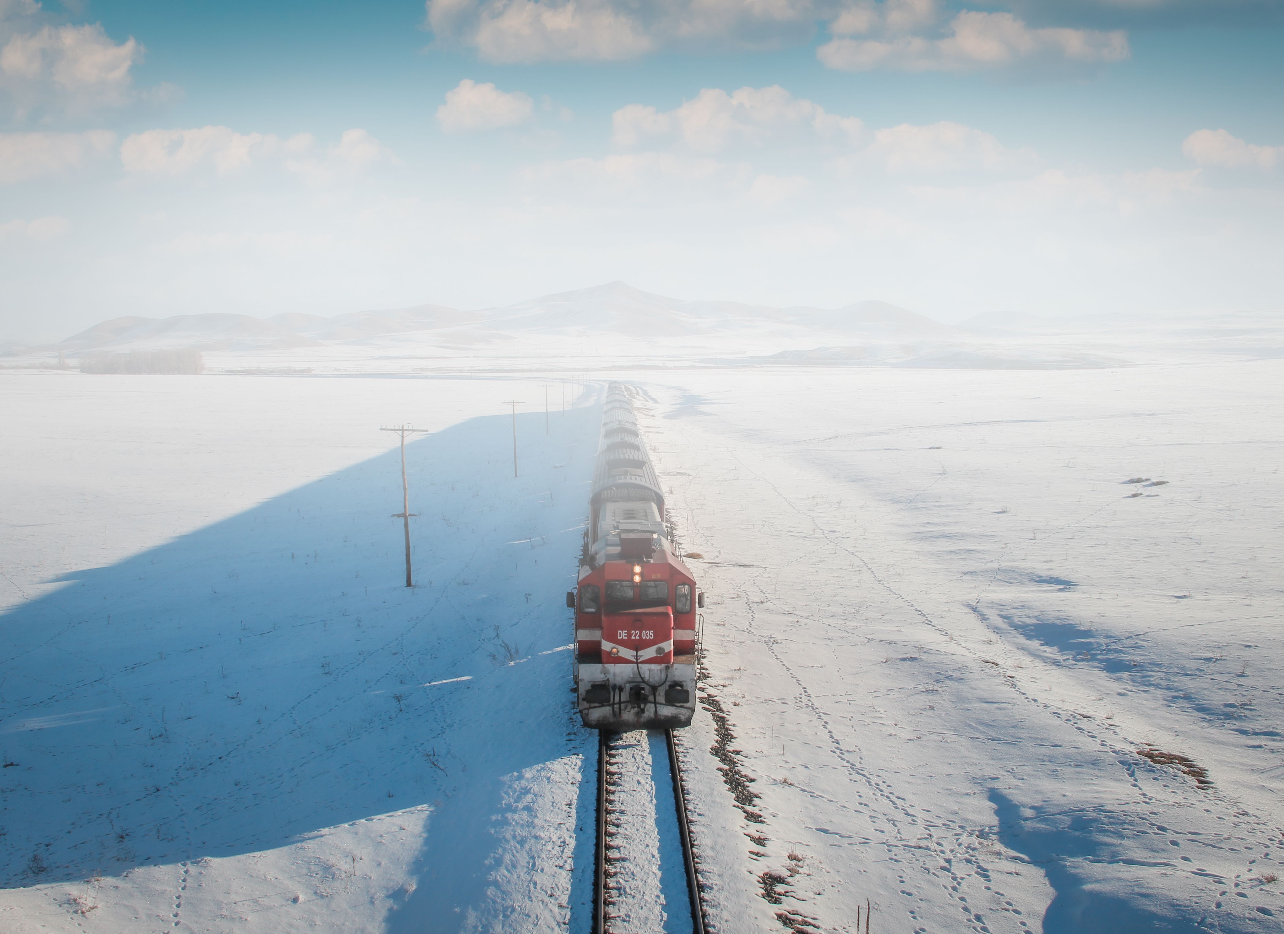 Red Train Traversing Snow-Covered Landscape · Free Stock Photo