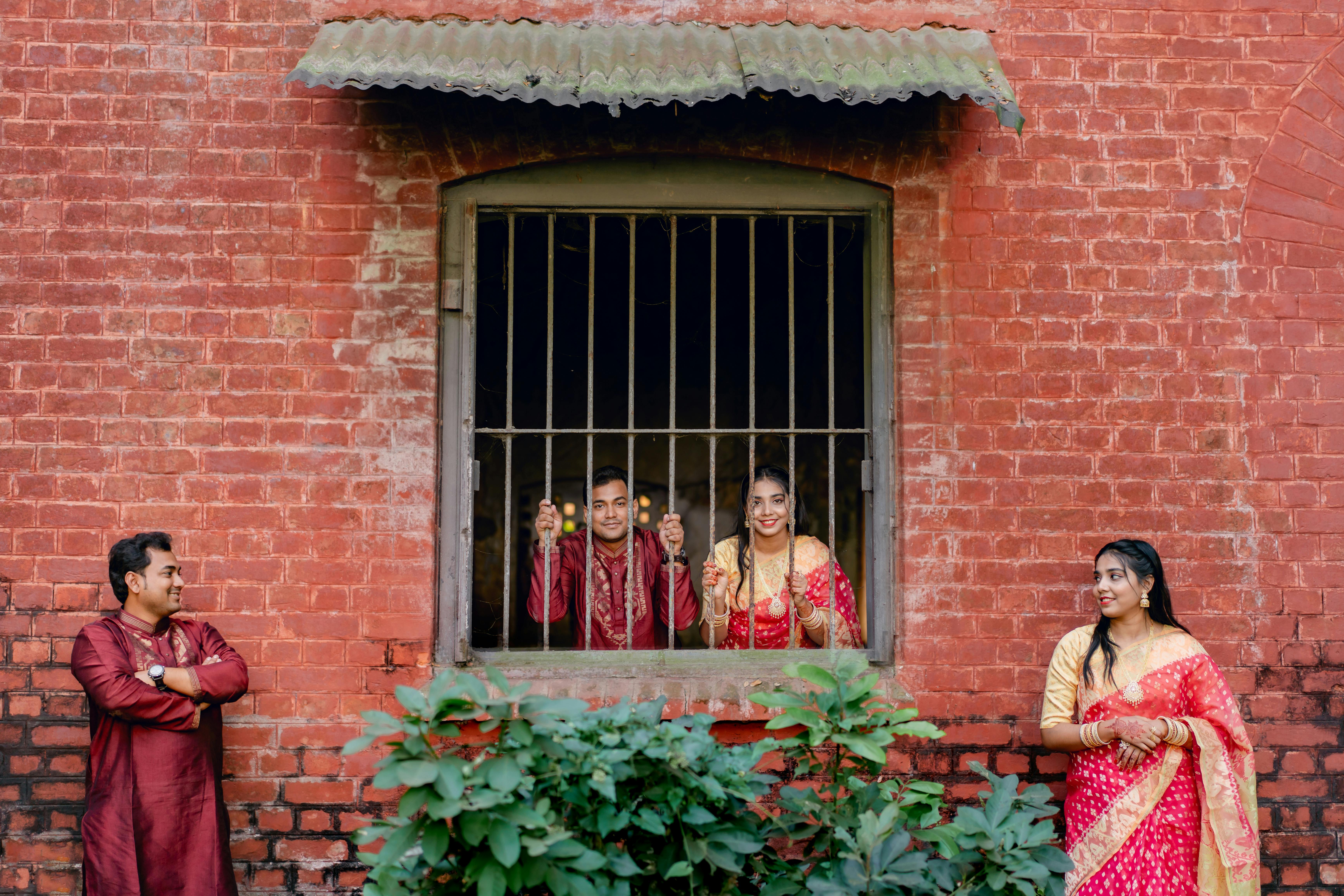 Group Portrait in Traditional Attire by Brick Wall · Free Stock Photo