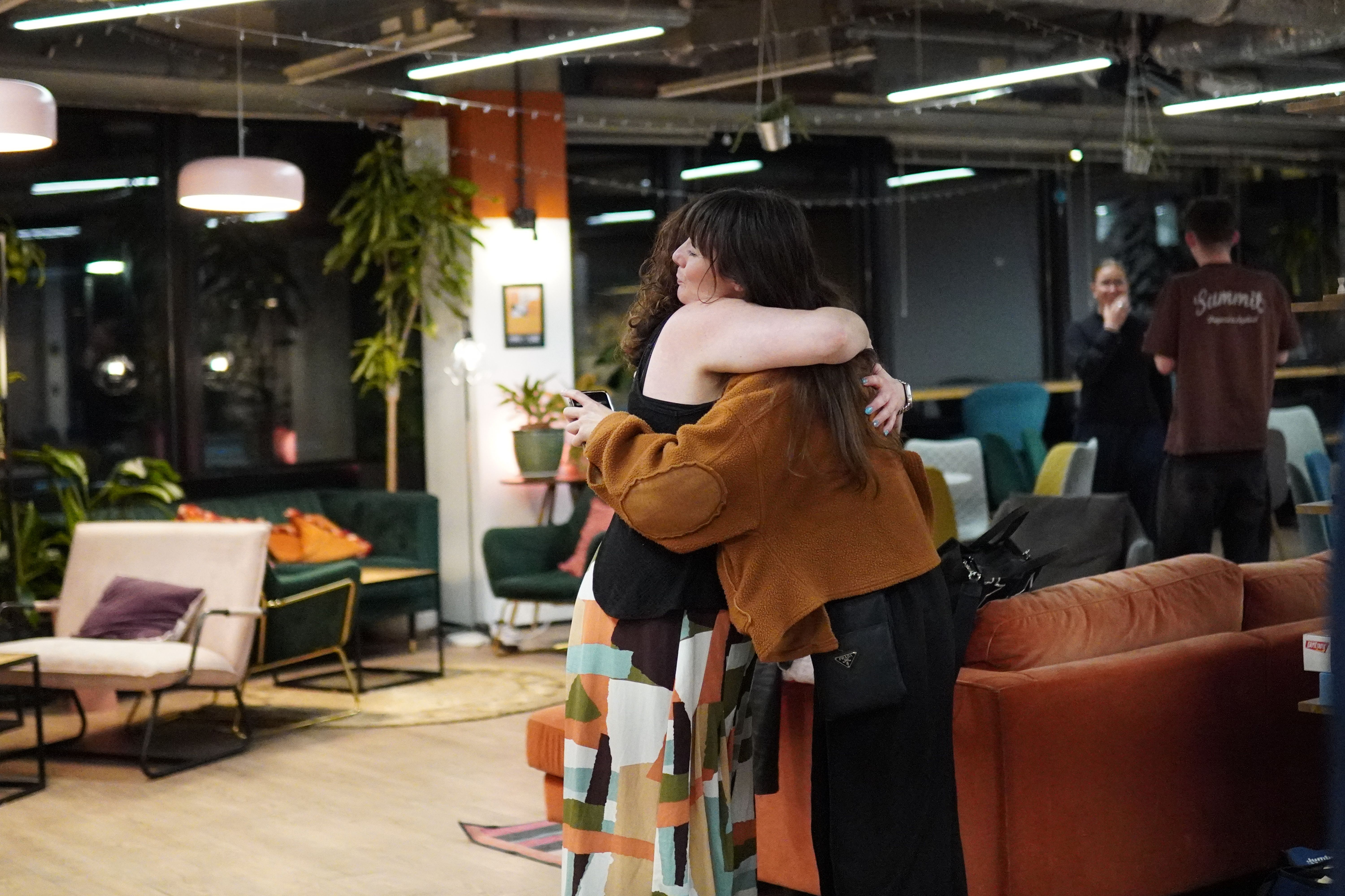Friendly Embrace in Modern Lounge Setting · Free Stock Photo