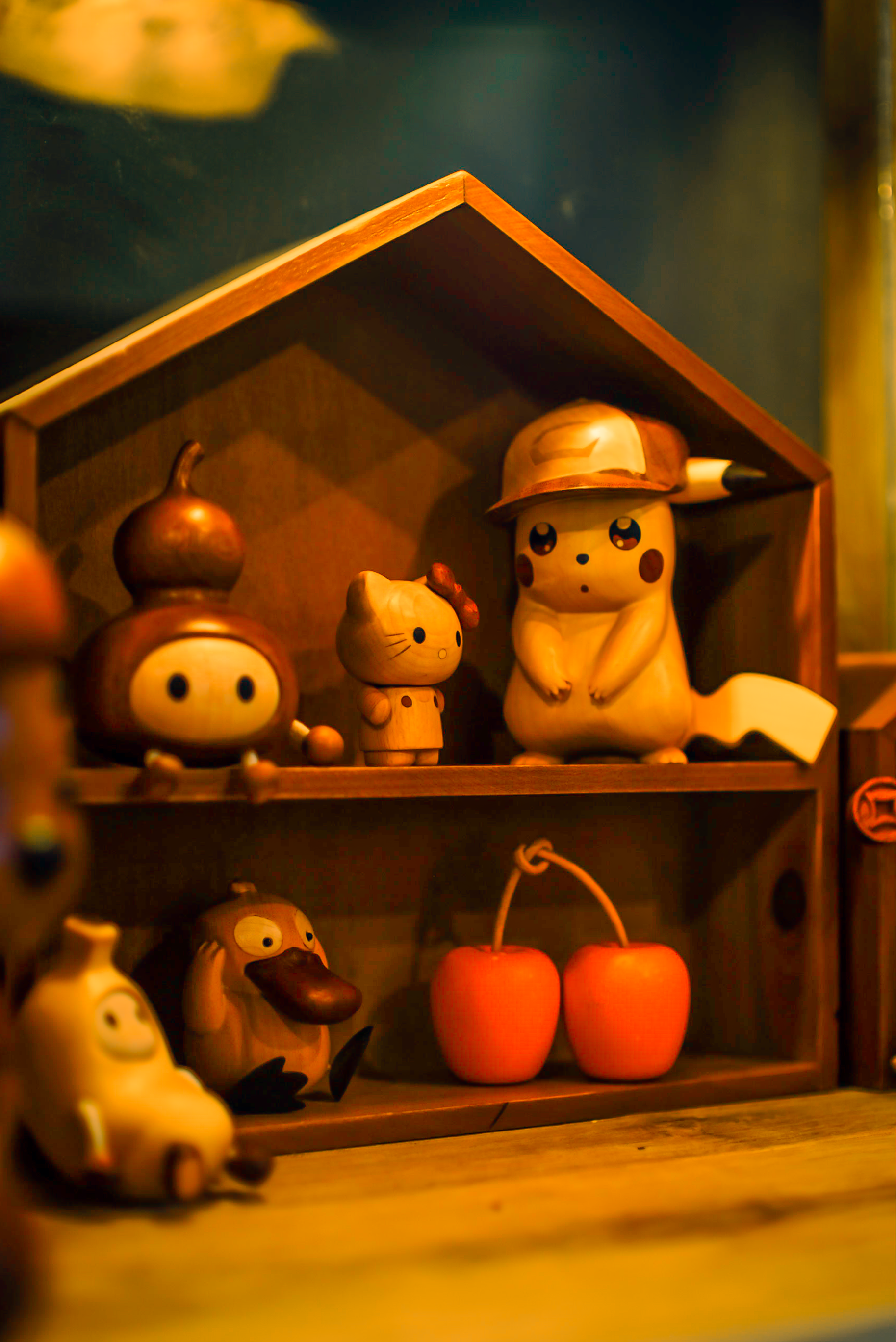 Cute Figurines in Wooden Display Under Warm Light · Free Stock Photo