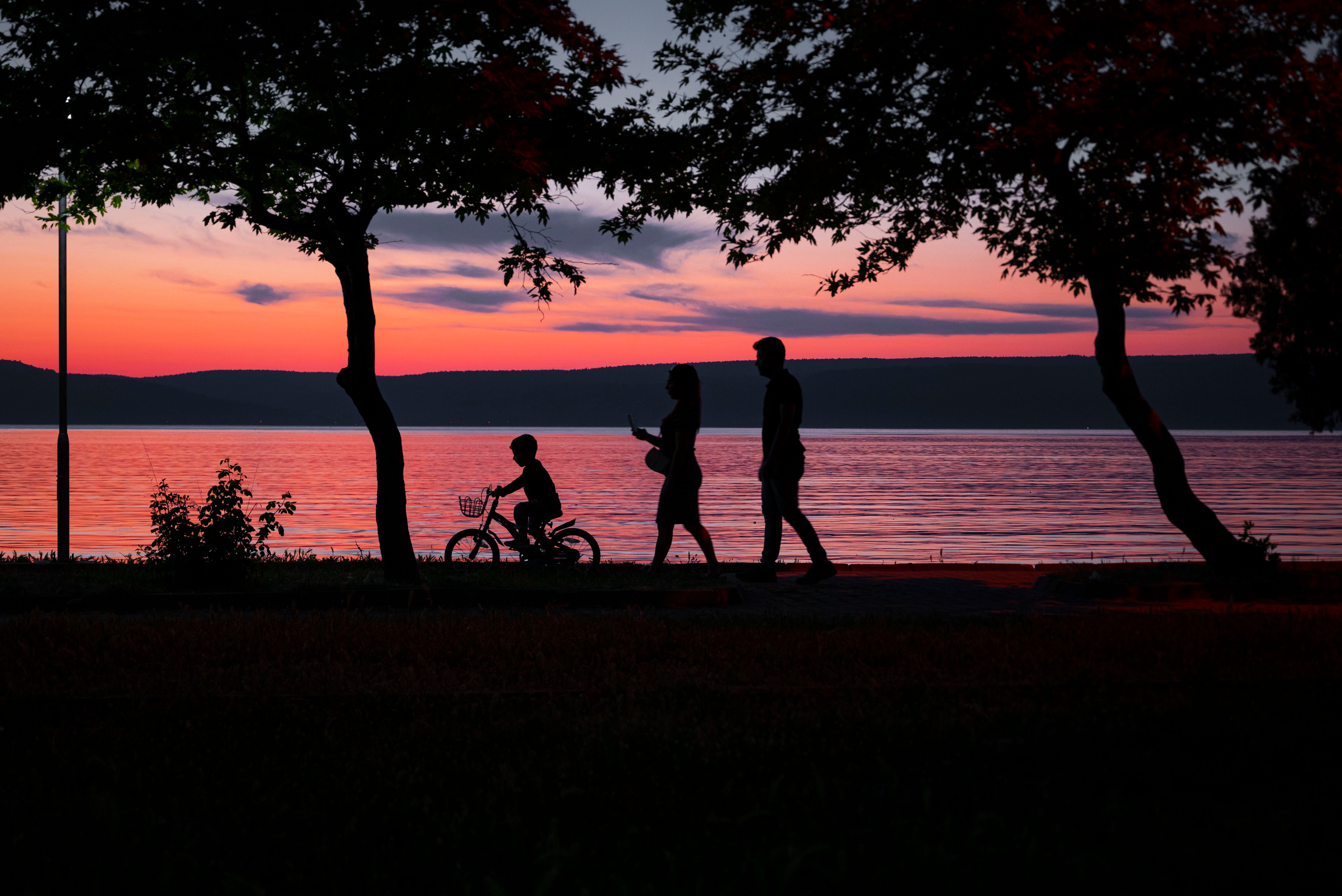 Family Stroll Along Lakeshore at Dusk · Free Stock Photo