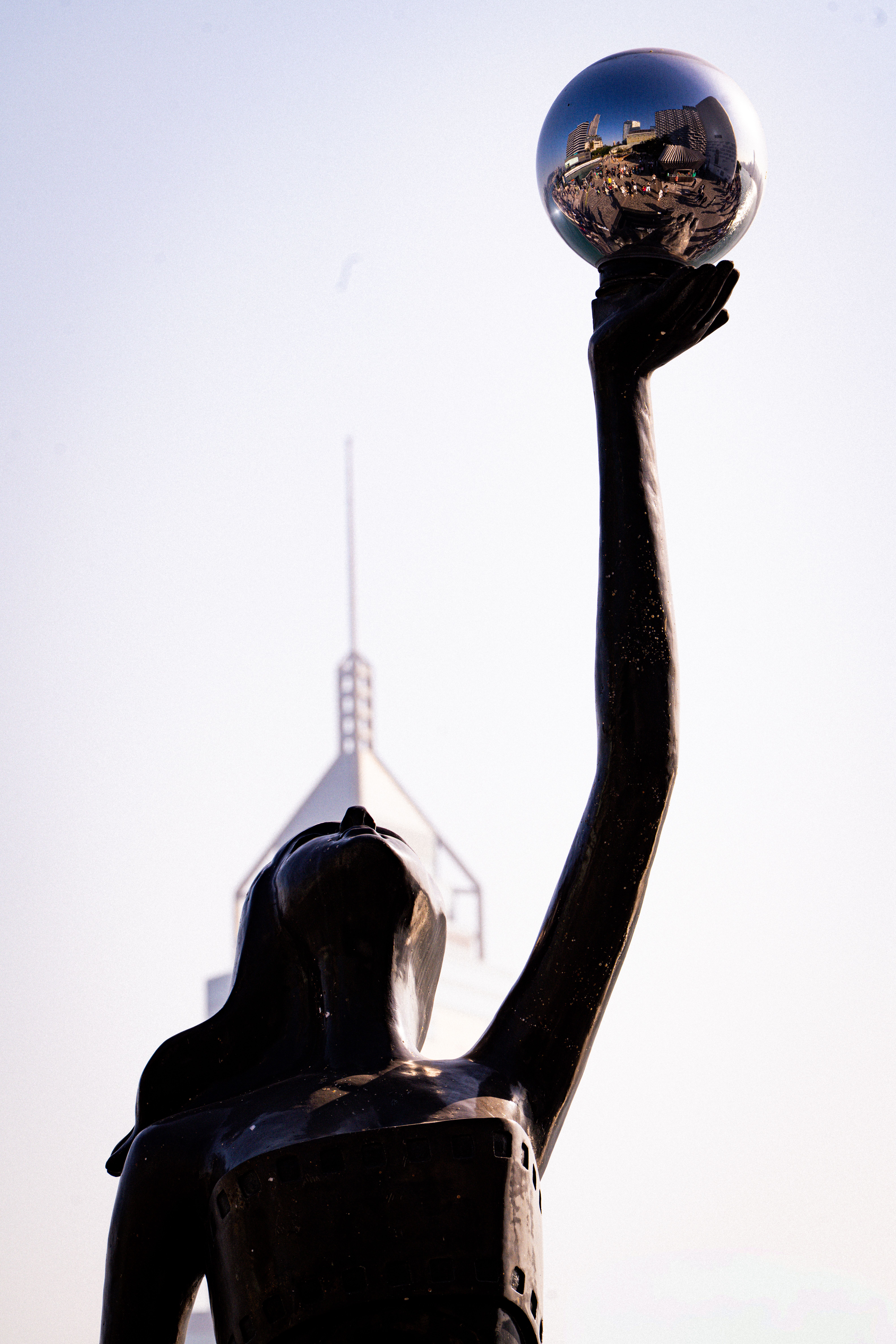 Artistic Statue Holding Reflective Sphere Outdoors · Free Stock Photo