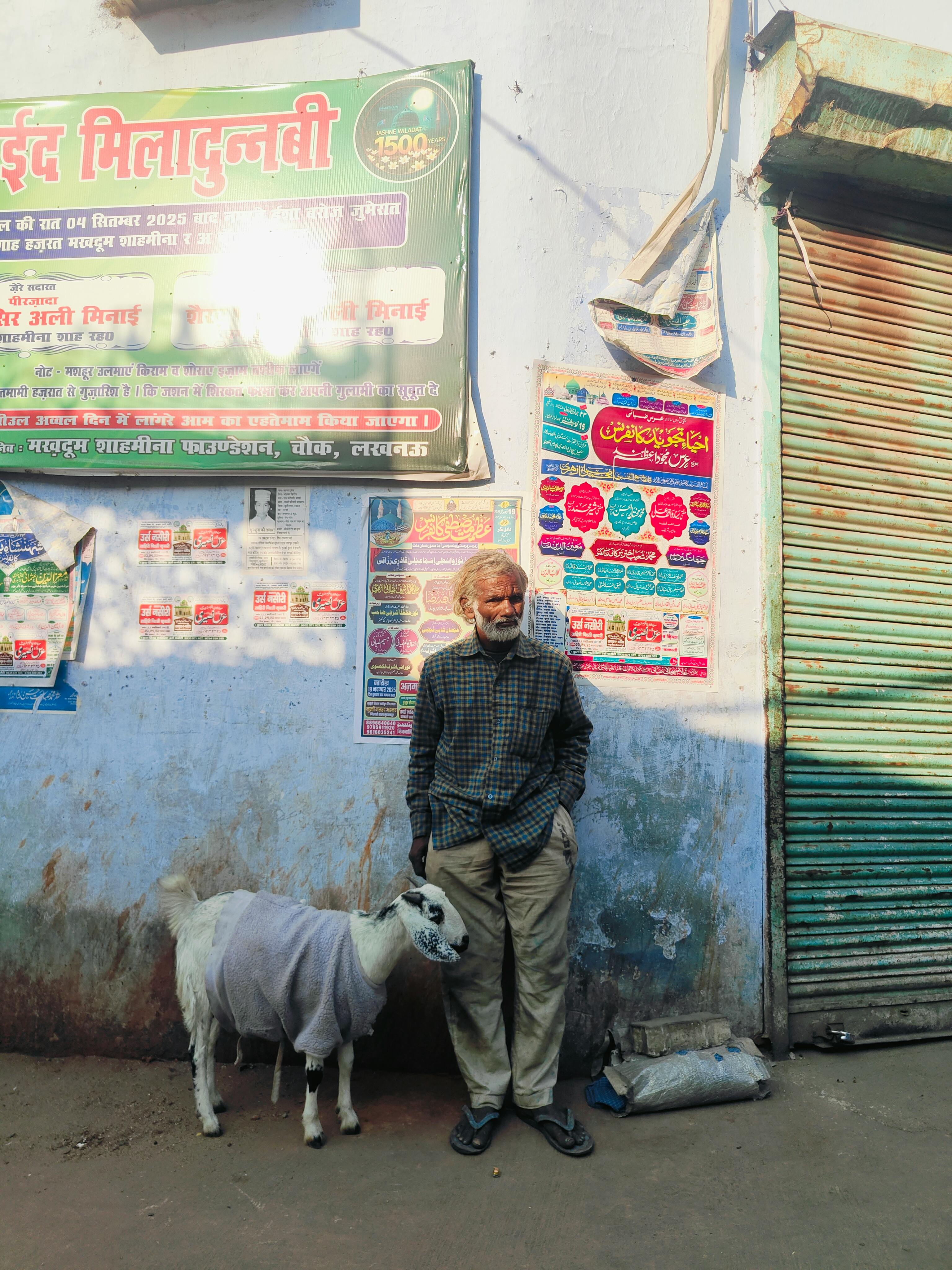 Elderly Man Standing with Goat on Sidewalk · Free Stock Photo
