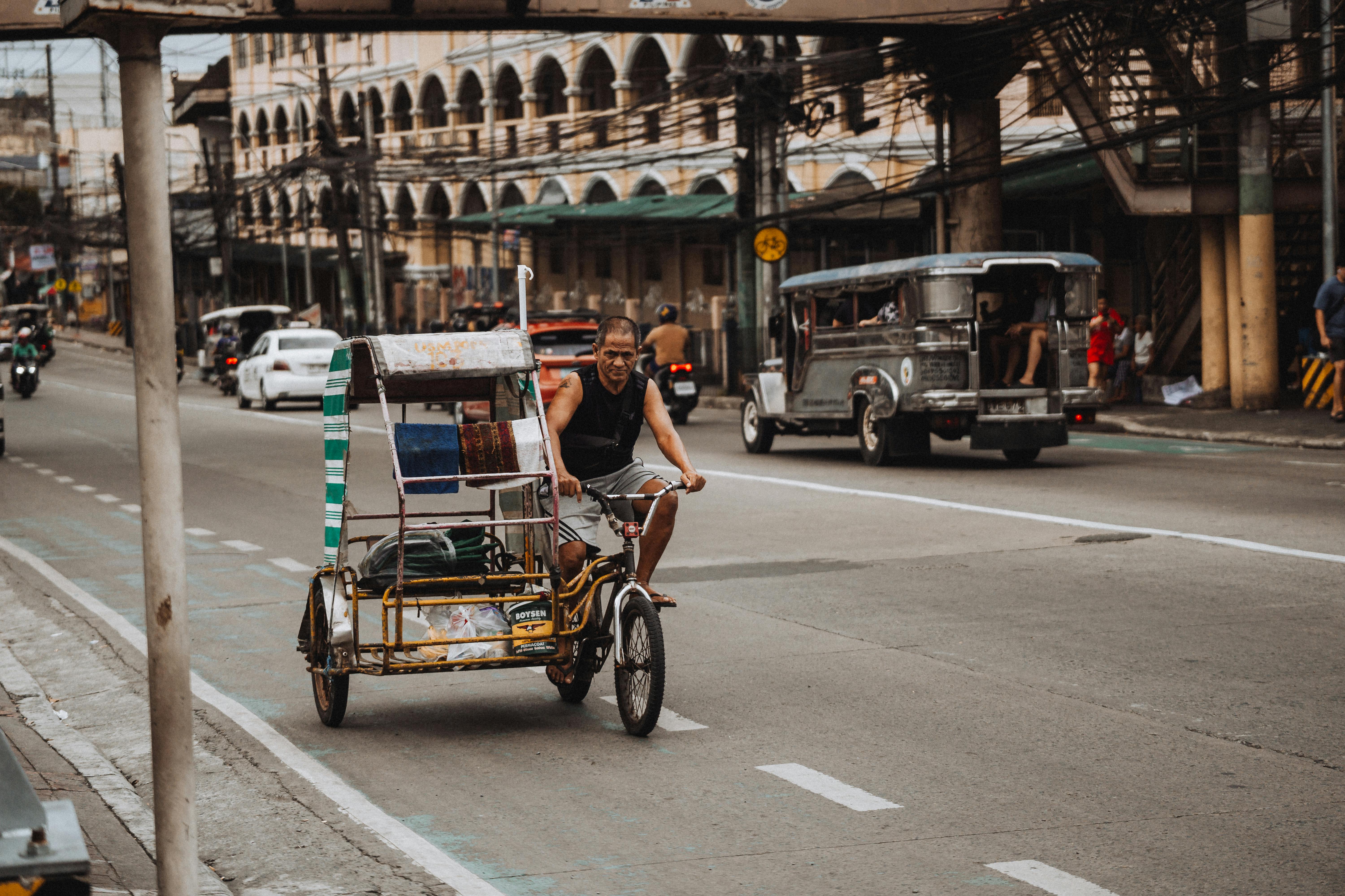 Tricycle Rider on Bustling City Street · Free Stock Photo