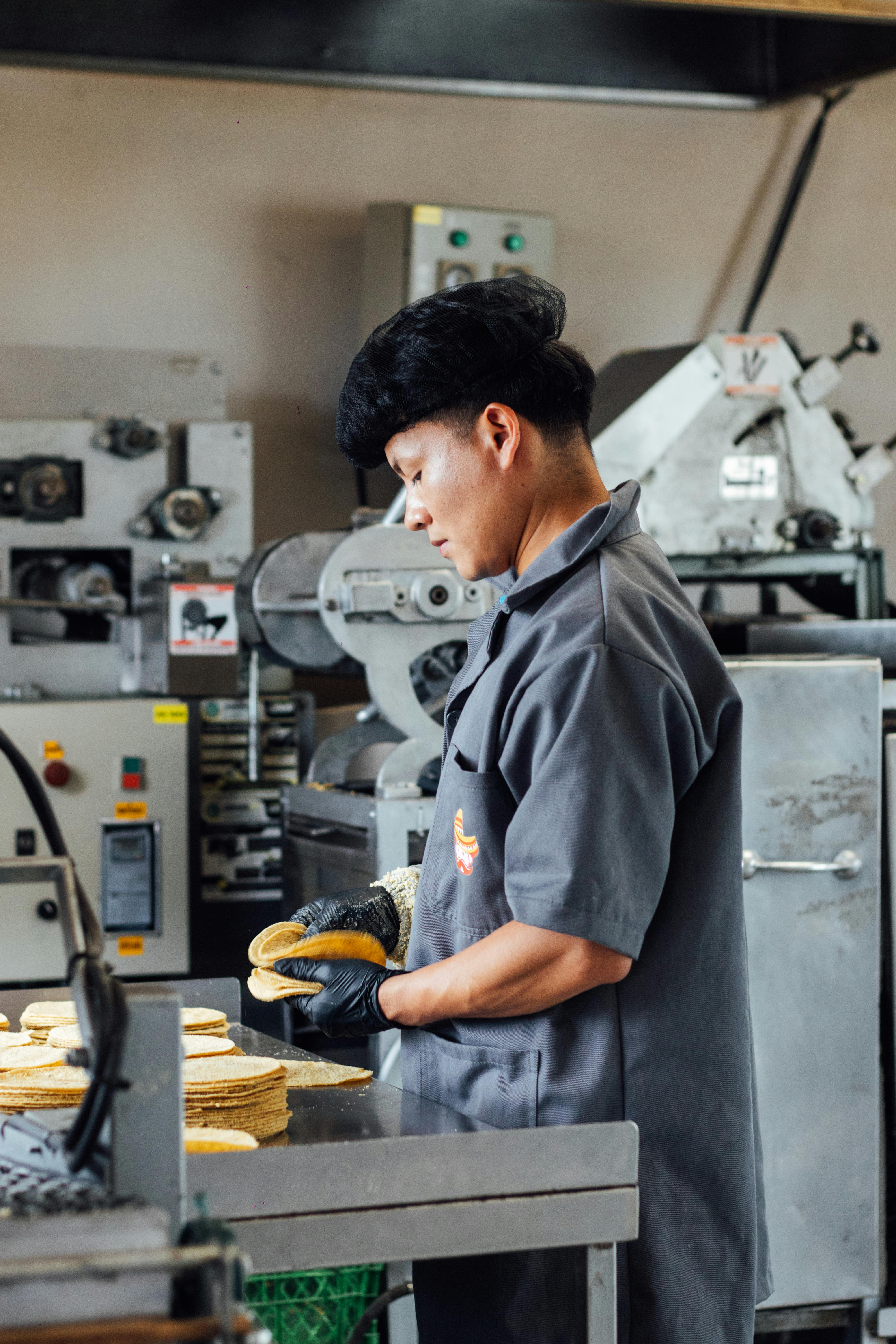 Hombre Trabajando En Una Panadería Industrial · Foto de stock gratuita