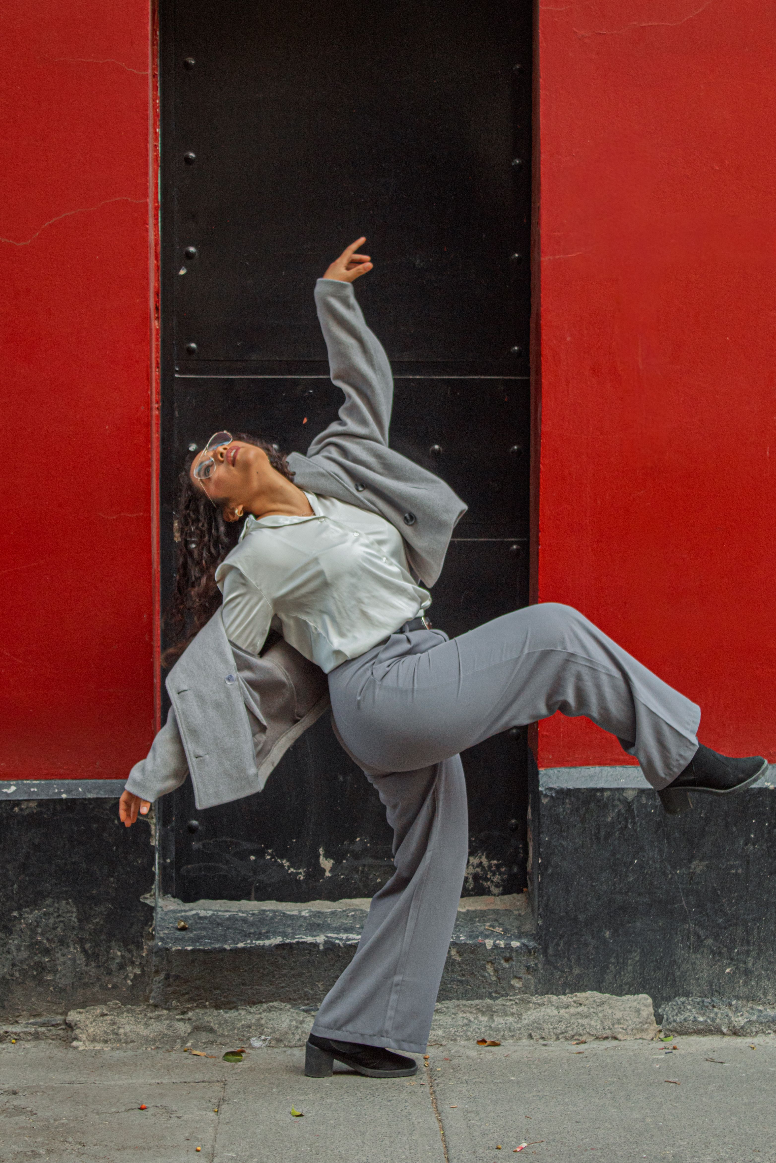 Graceful Dance Pose Against Red Urban Wall · Free Stock Photo