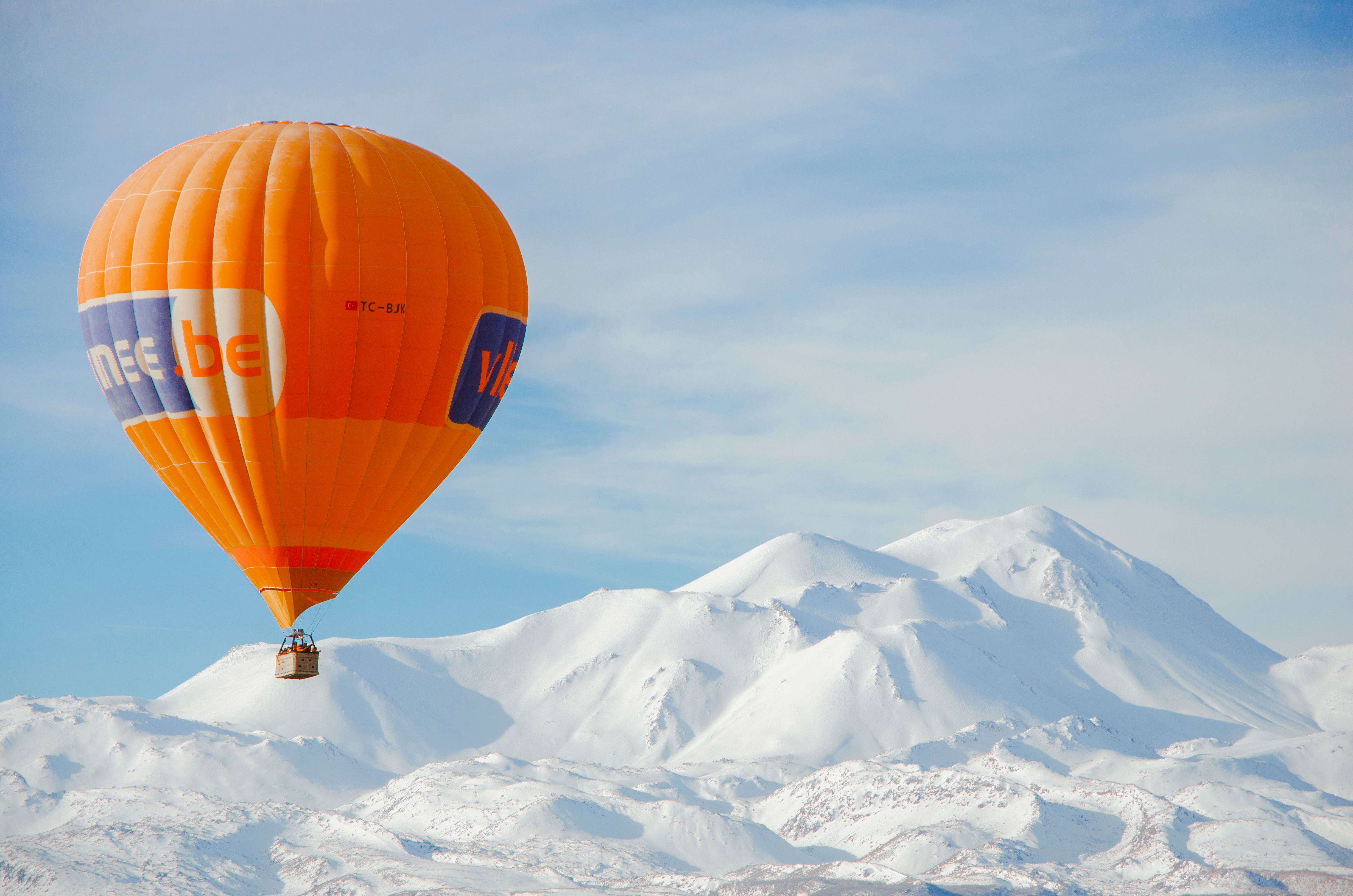 Vibrant Hot Air Balloon Over Snowy Mountains · Free Stock Photo