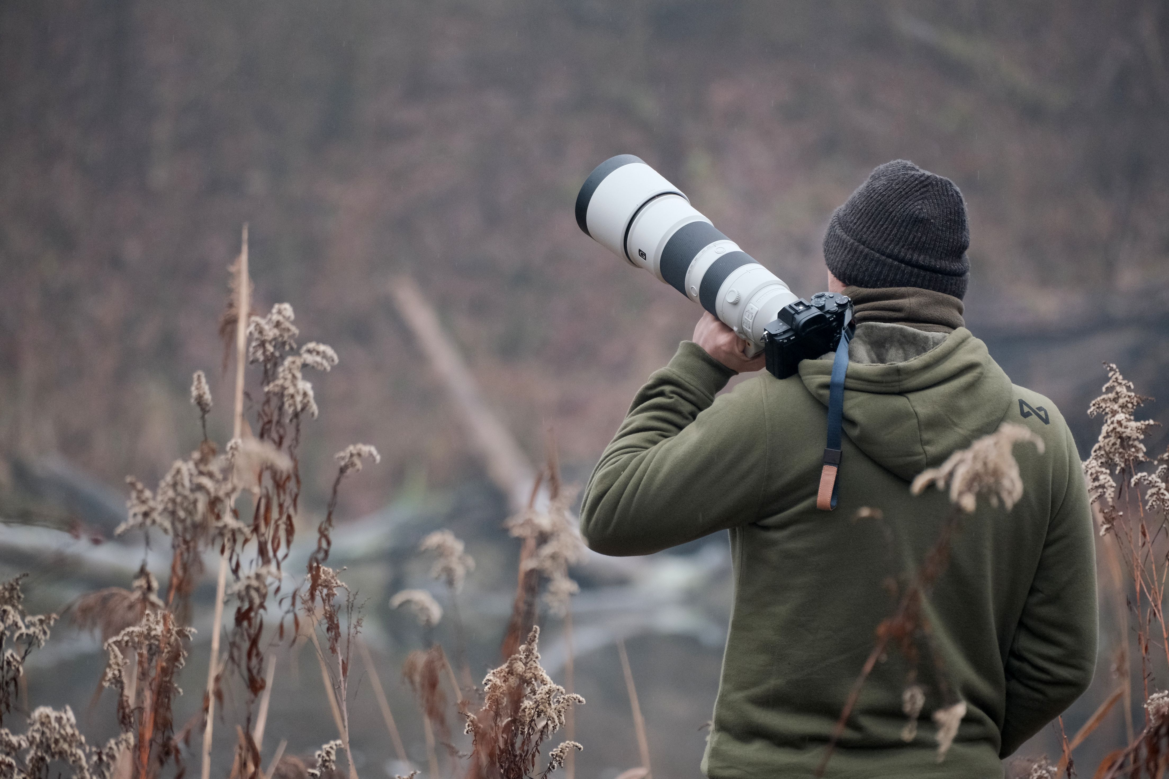 Back View of Photographer with Telephoto Lens Outdoors · Free Stock Photo