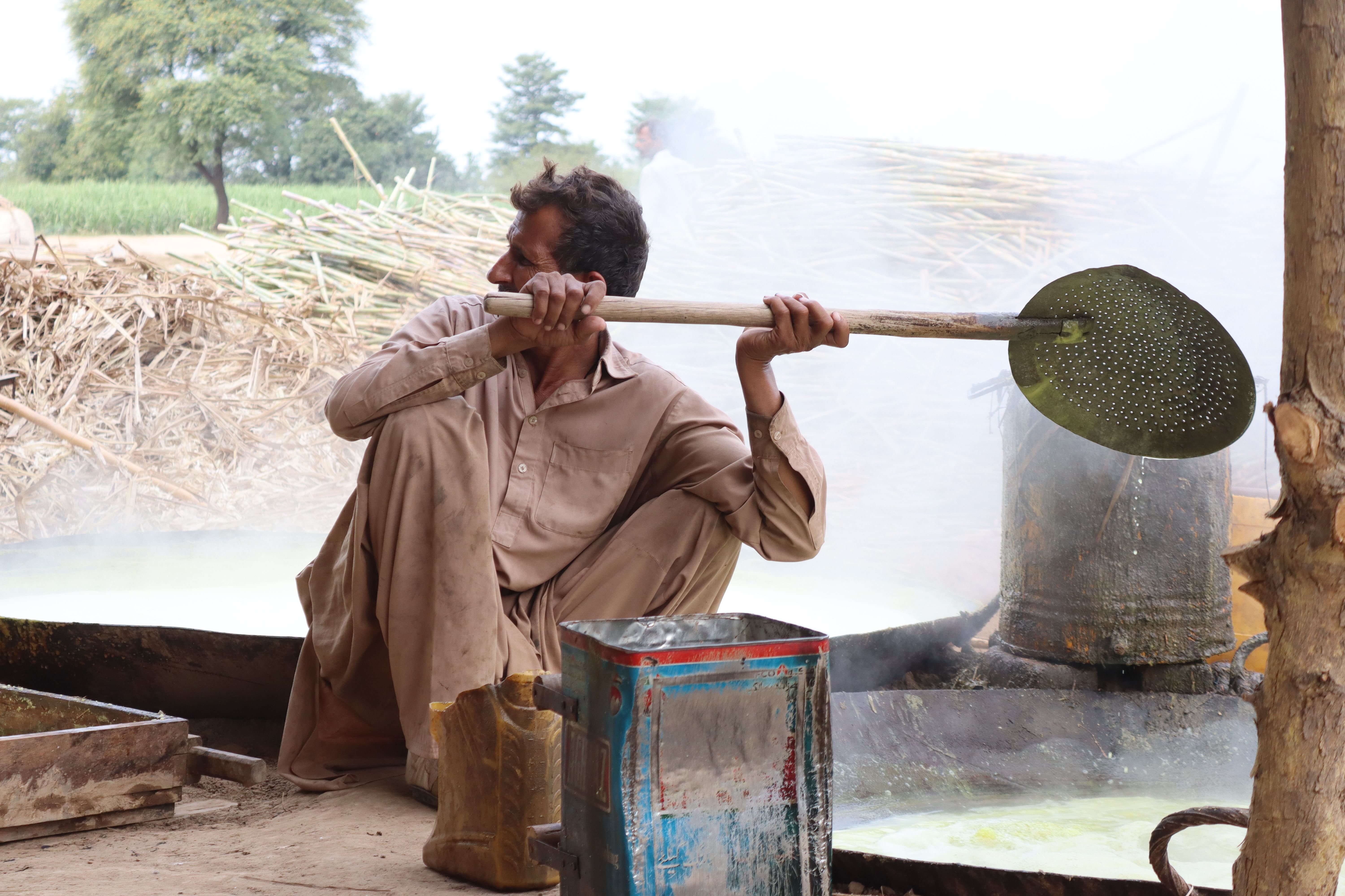 Rustic Outdoor Farming Scene with Worker Stirring Sugarcane · Free ...