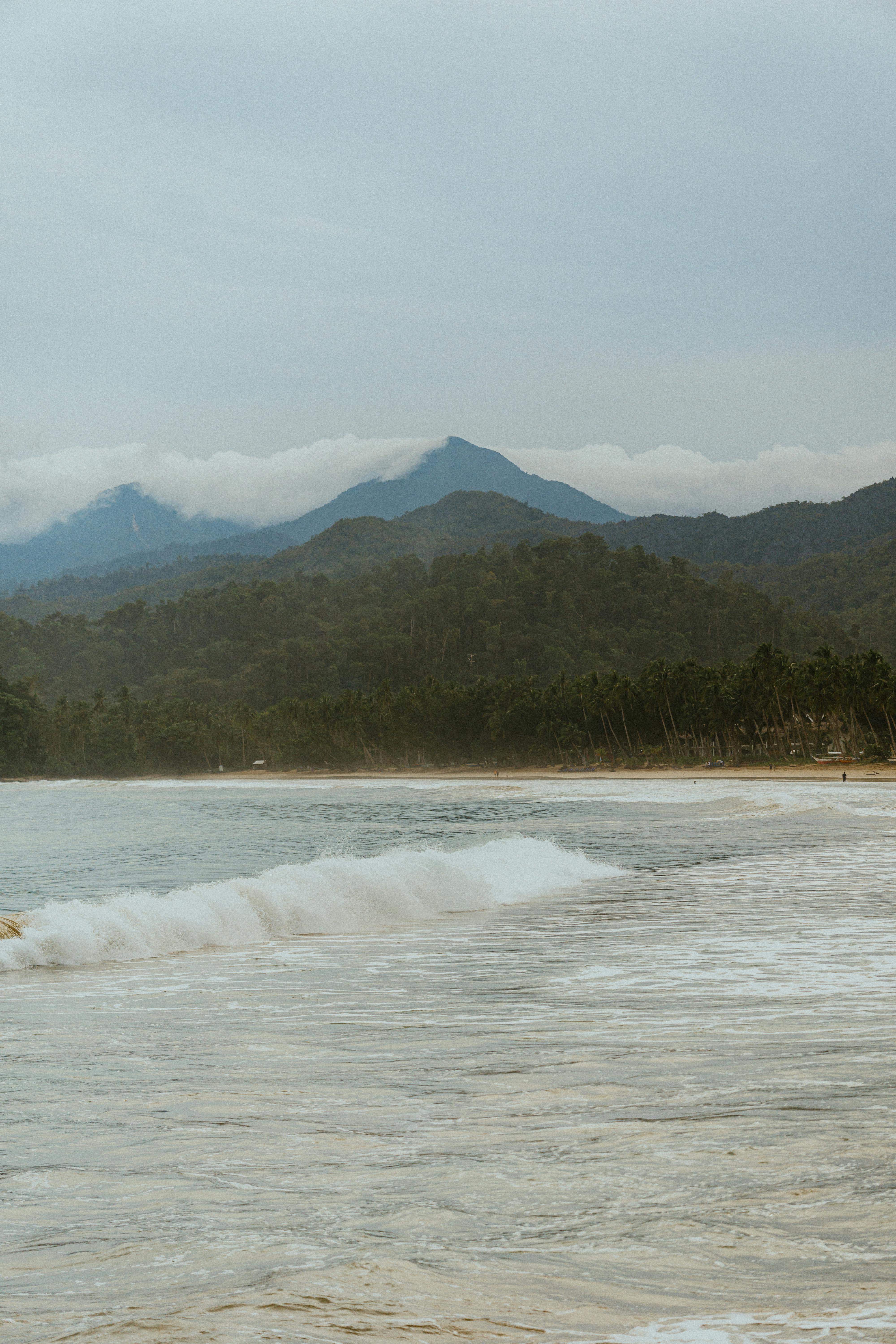 Tranquil Beach with Mountainous Backdrop · Free Stock Photo