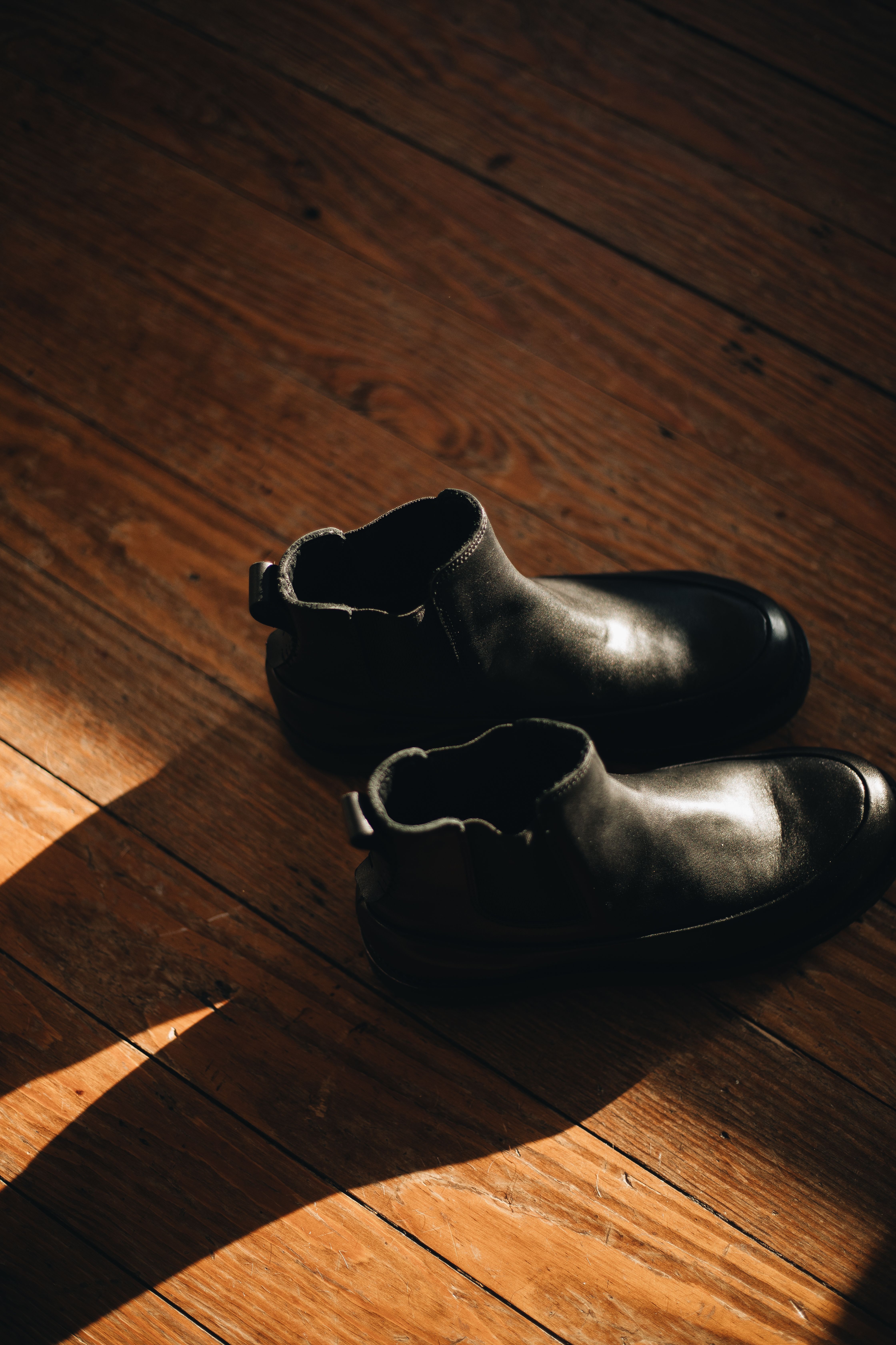 Elegant Leather Boots on Rustic Wooden Floor · Free Stock Photo