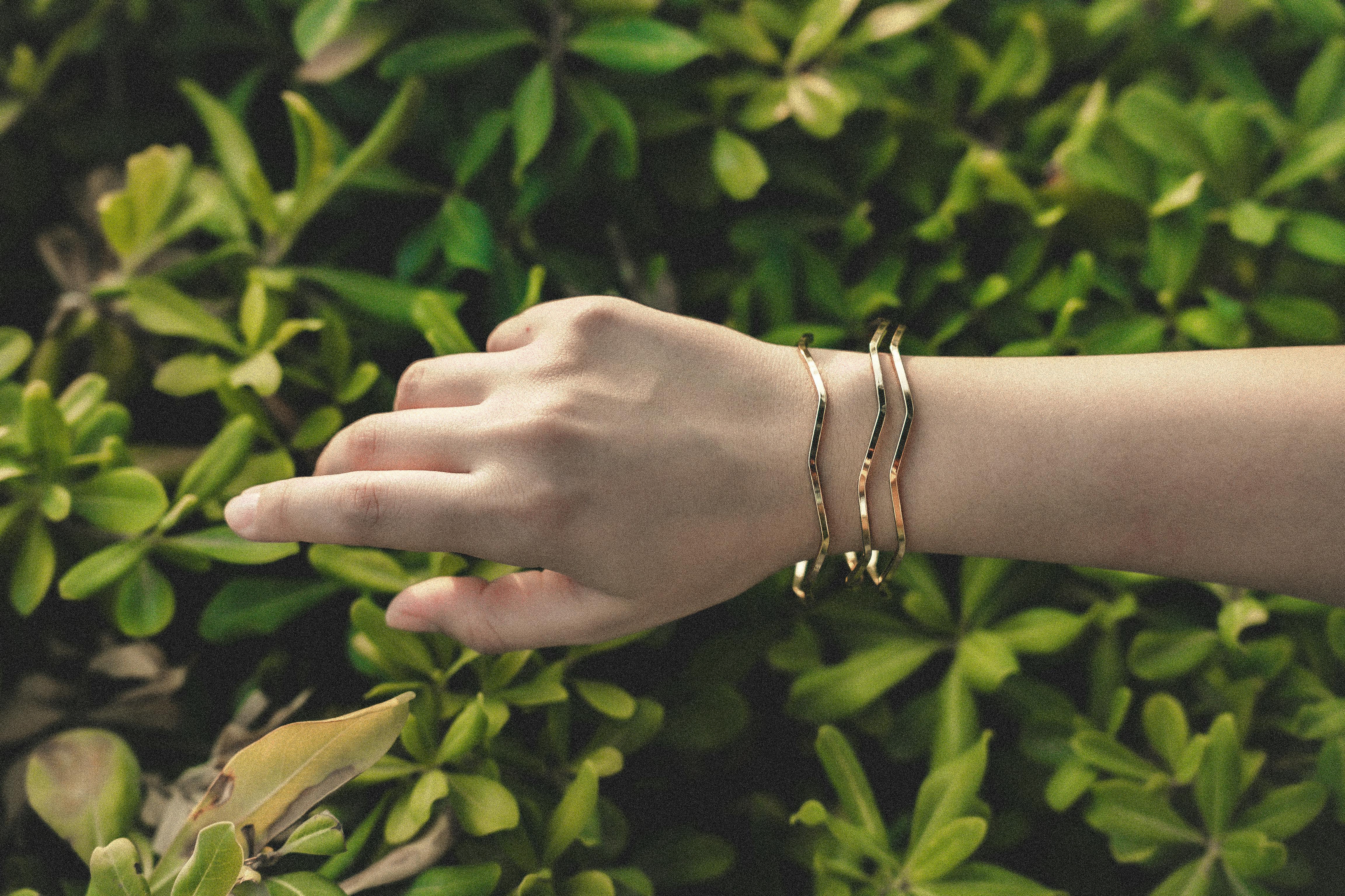 Mano Minimalista Con Pulseras De Oro En La Naturaleza · Foto de stock ...