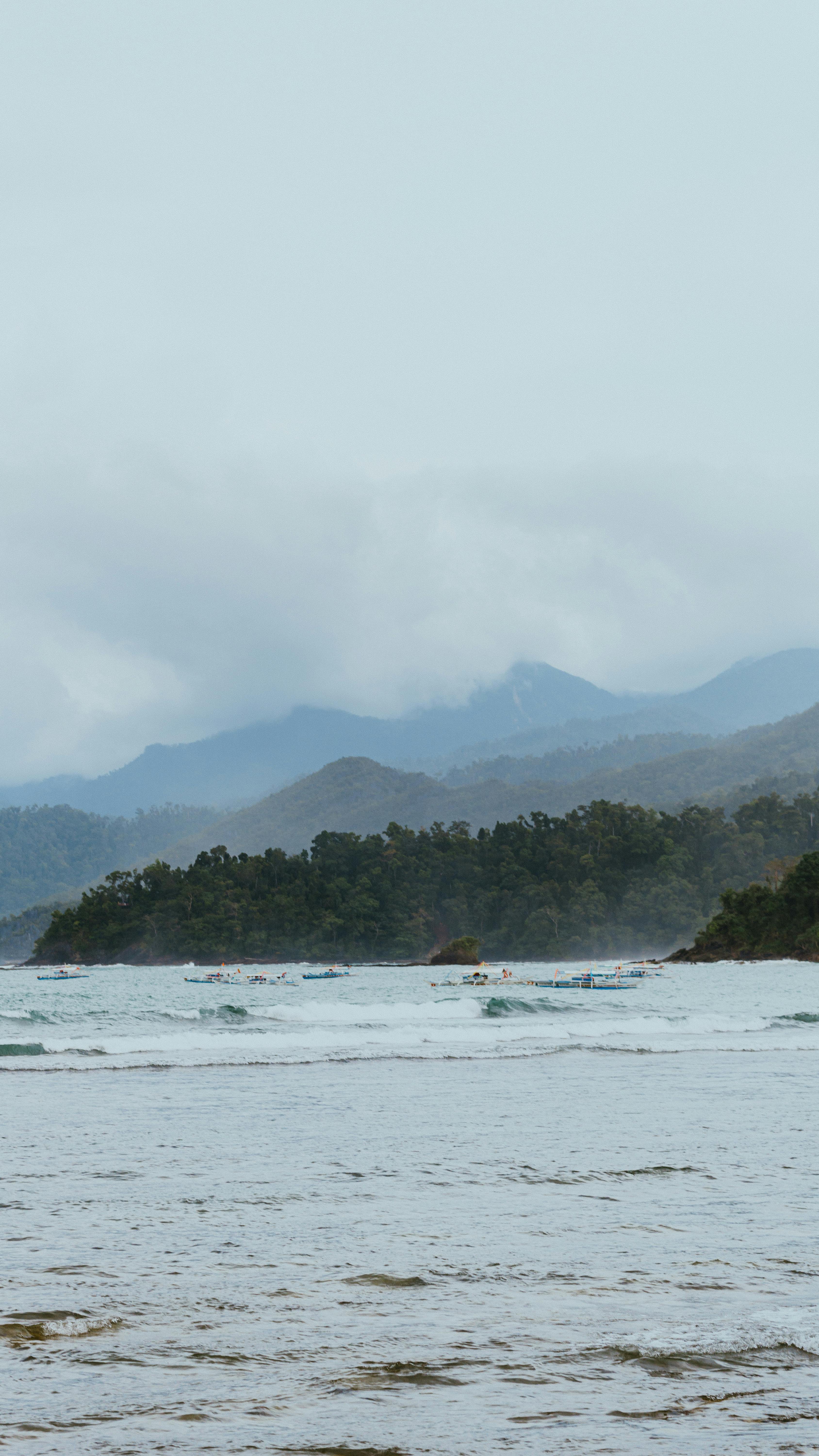 Tranquil Beach with Mountainous Backdrop · Free Stock Photo