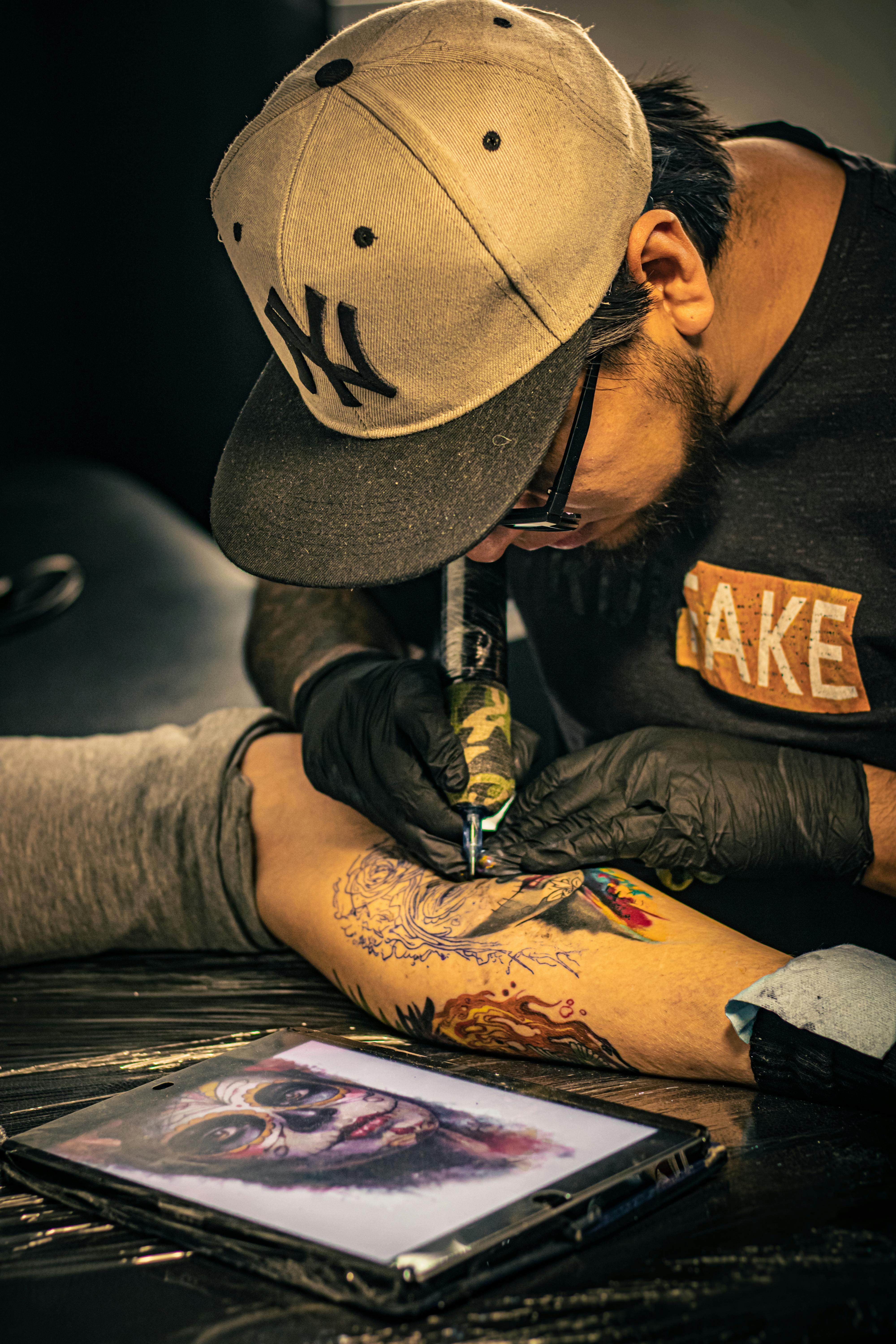 Skilled Tattoo Artist Creating Unique Arm Design · Free Stock Photo
