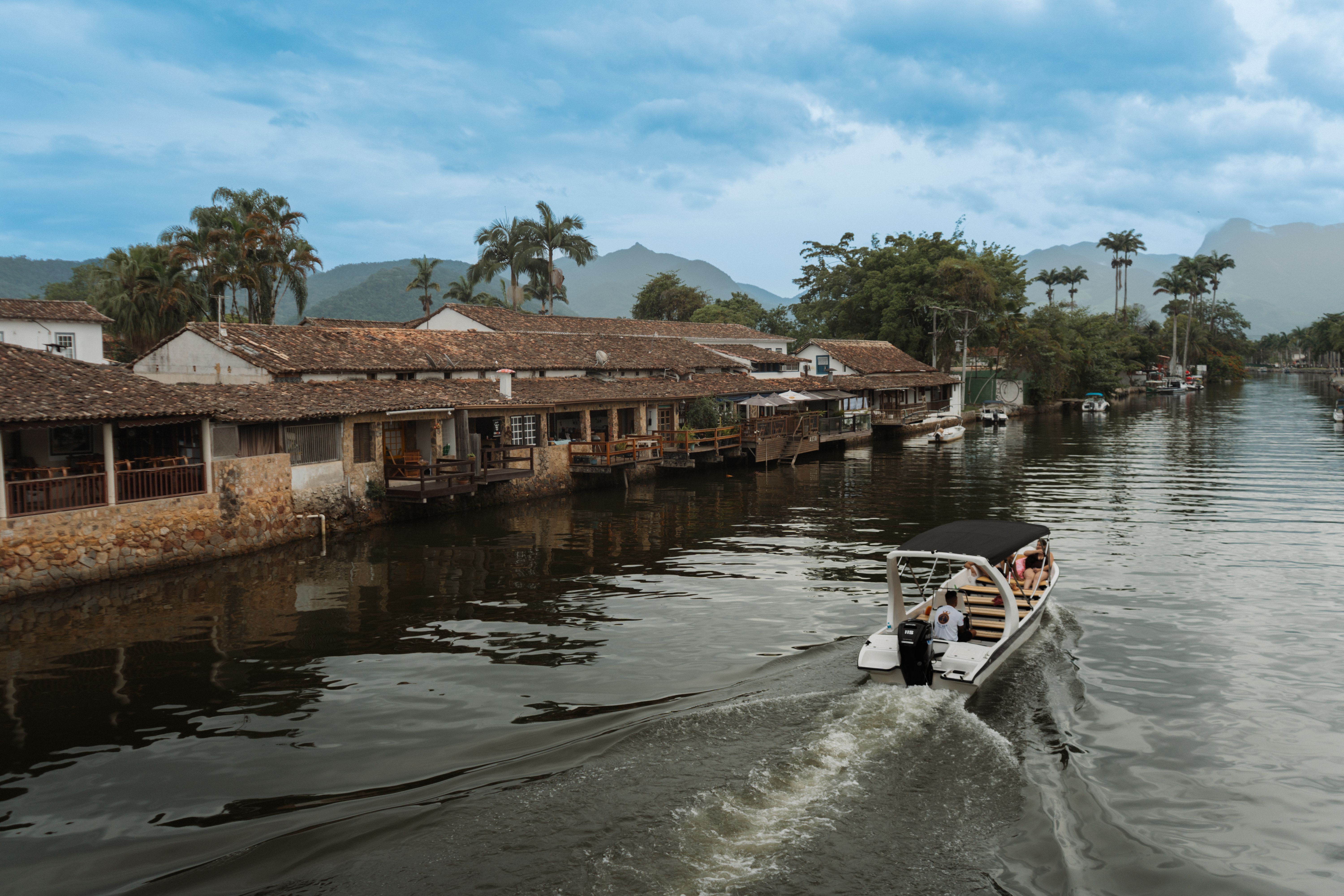 Scenic Boat Ride Along Riverside Village · Free Stock Photo
