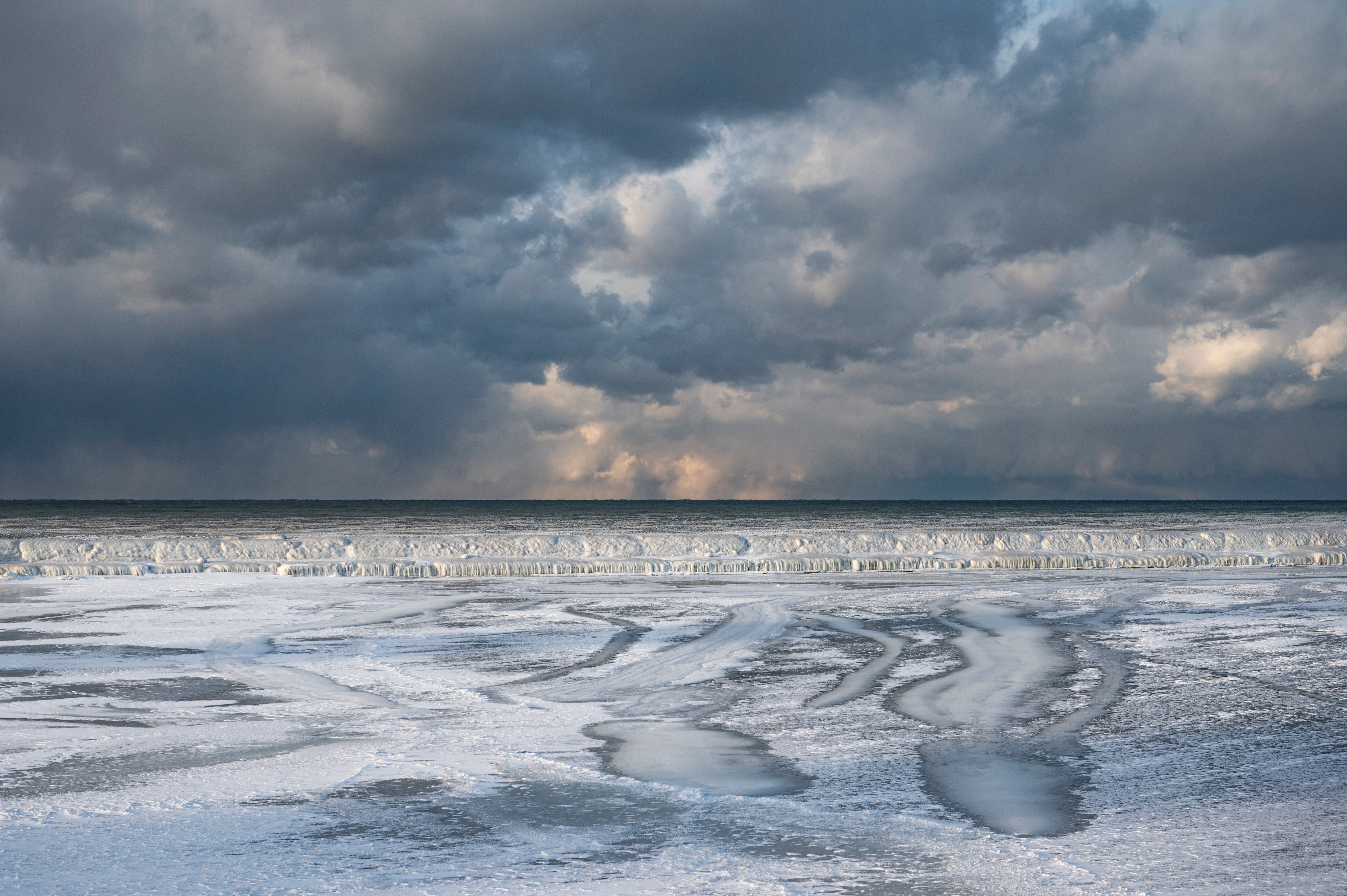 Frozen Seashore Under Dramatic Clouds in Winter · Free Stock Photo