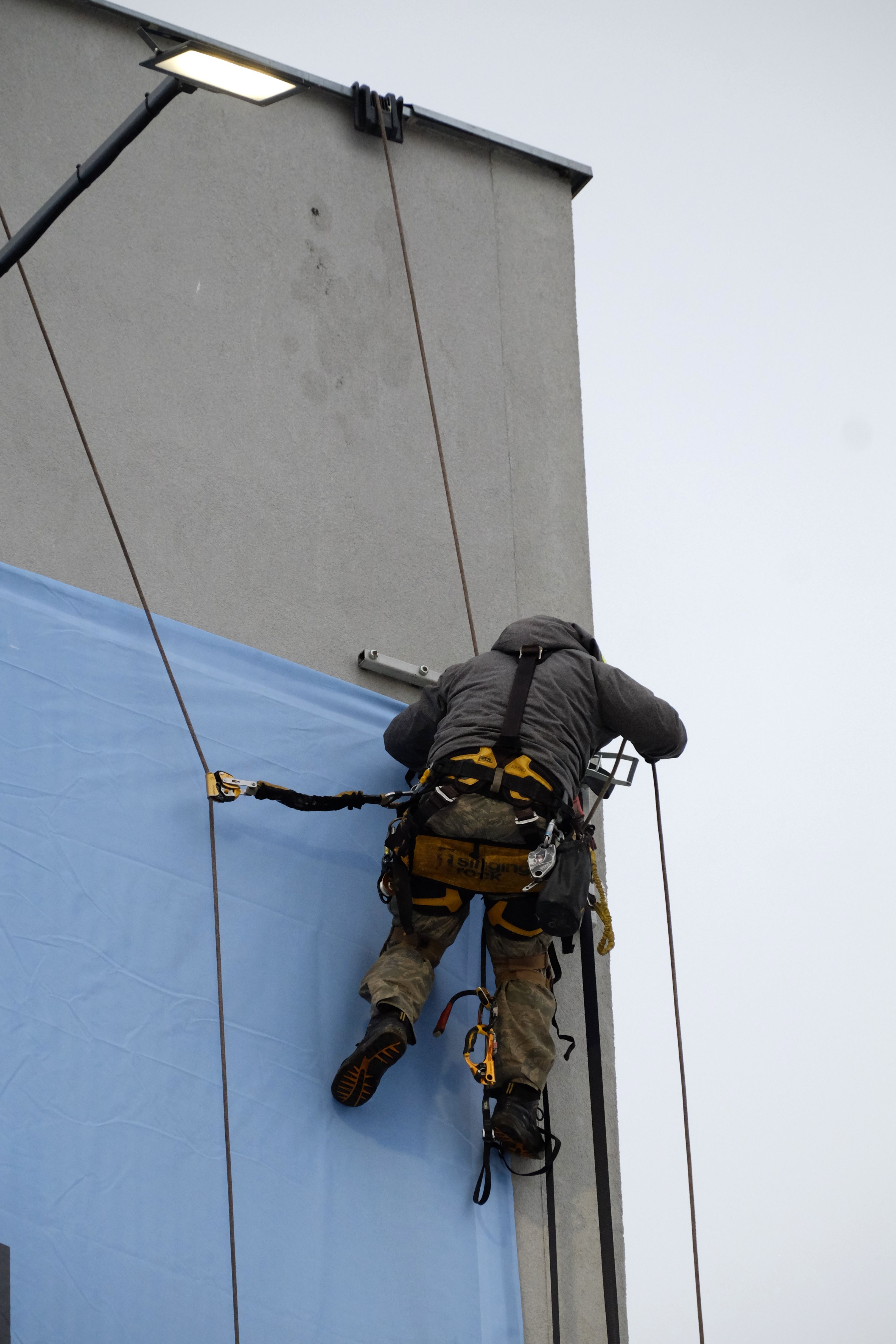 Rope Access Worker Installing Large Outdoor Banner · Free Stock Photo