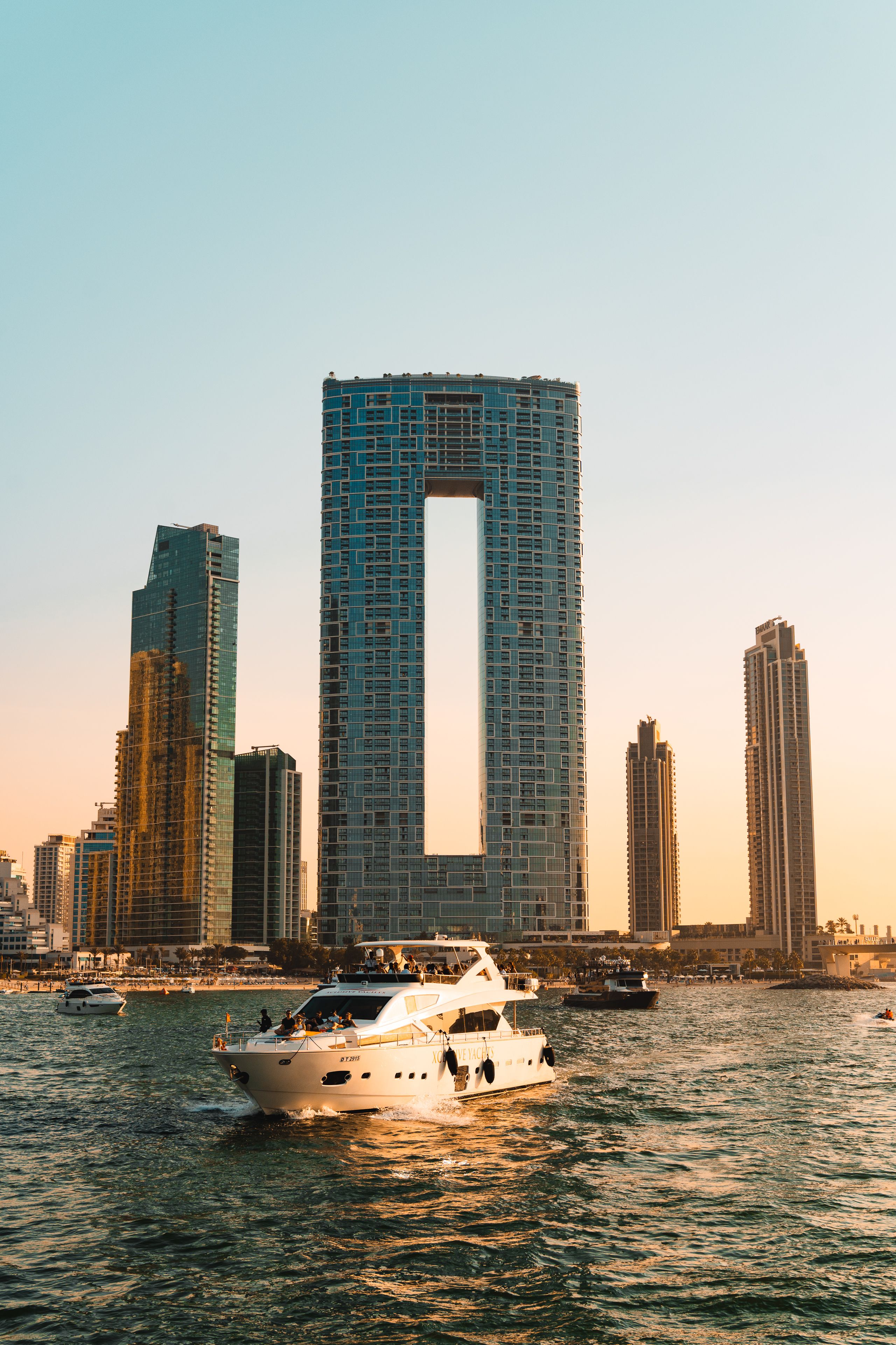 Luxury Yacht Sailing near Dubai's Iconic Skyscraper · Free Stock Photo