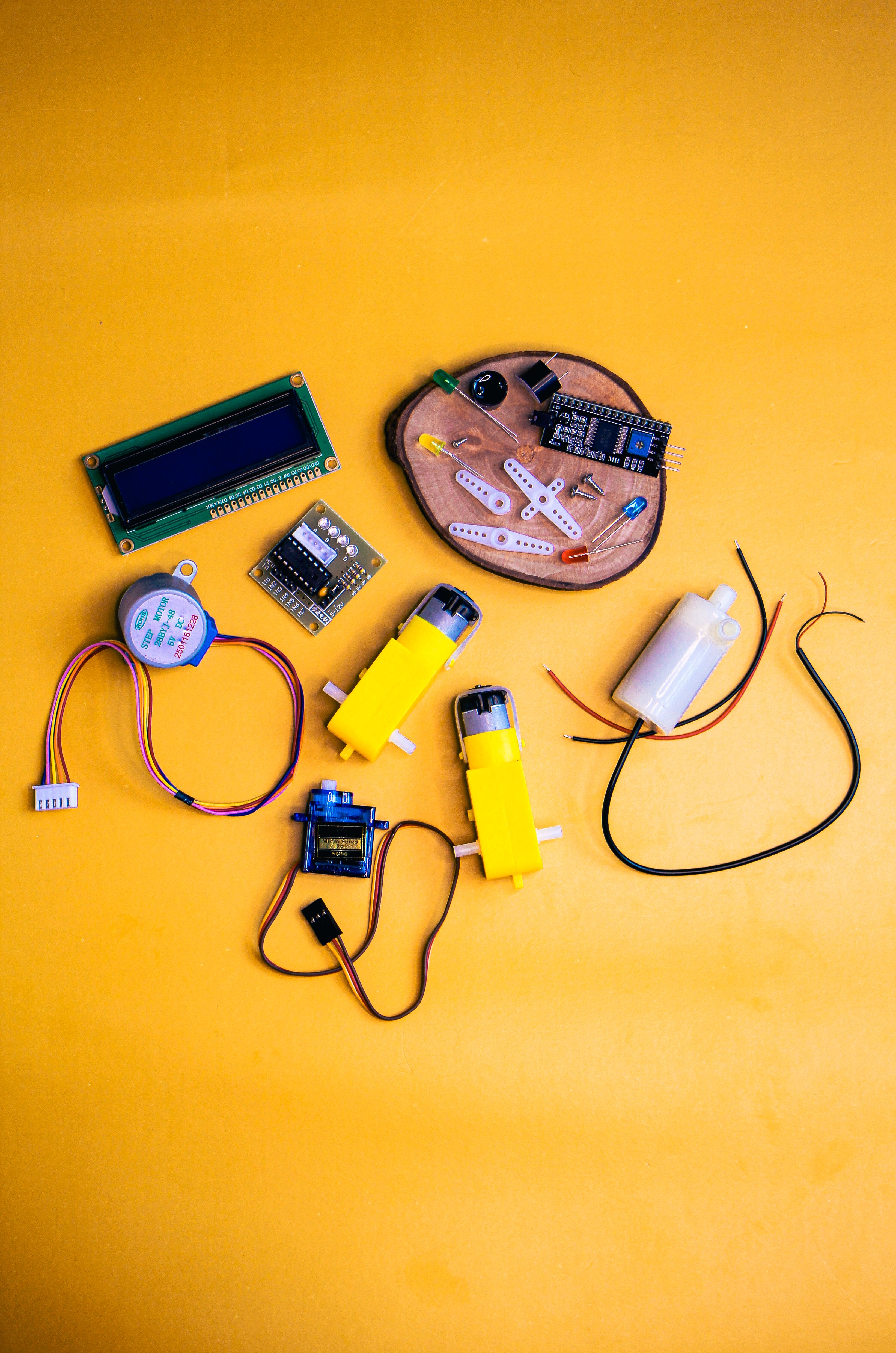 Colorful Robotics Components on Yellow Background · Free Stock Photo