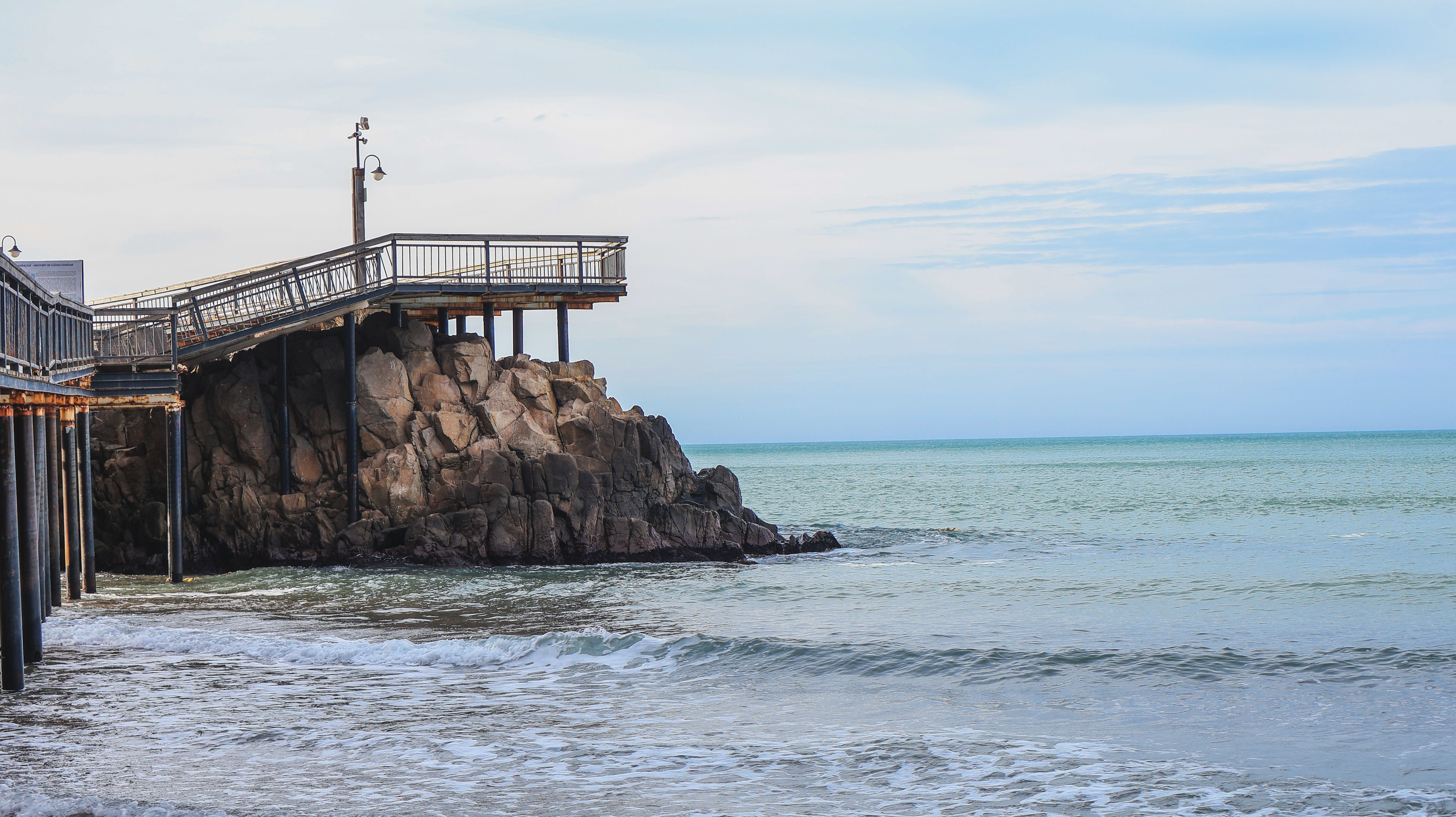 Scenic Ocean View with Wooden Pier and Rocky Coast · Free Stock Photo