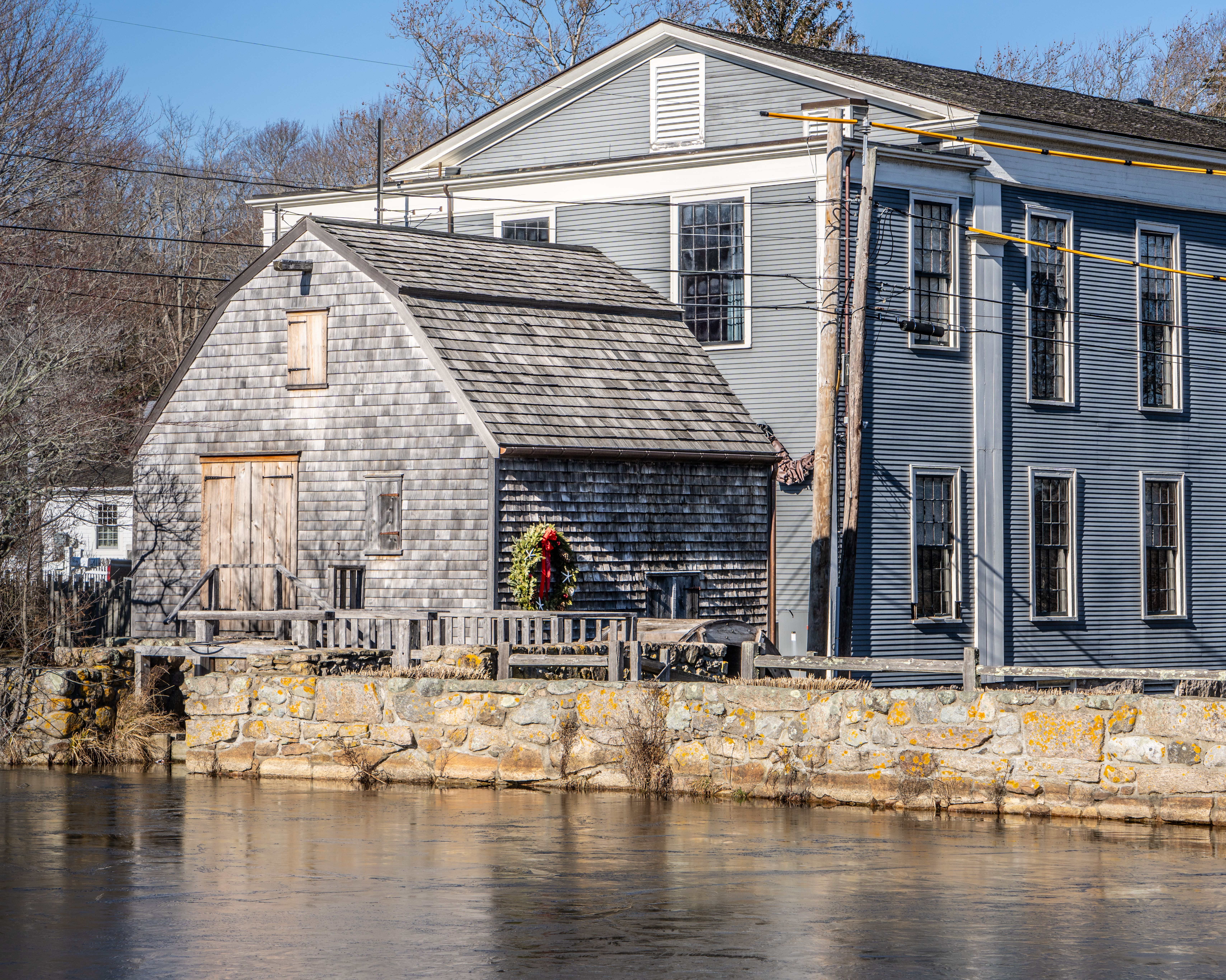 Historic Wooden Barn Beside Calm River in Winter · Free Stock Photo