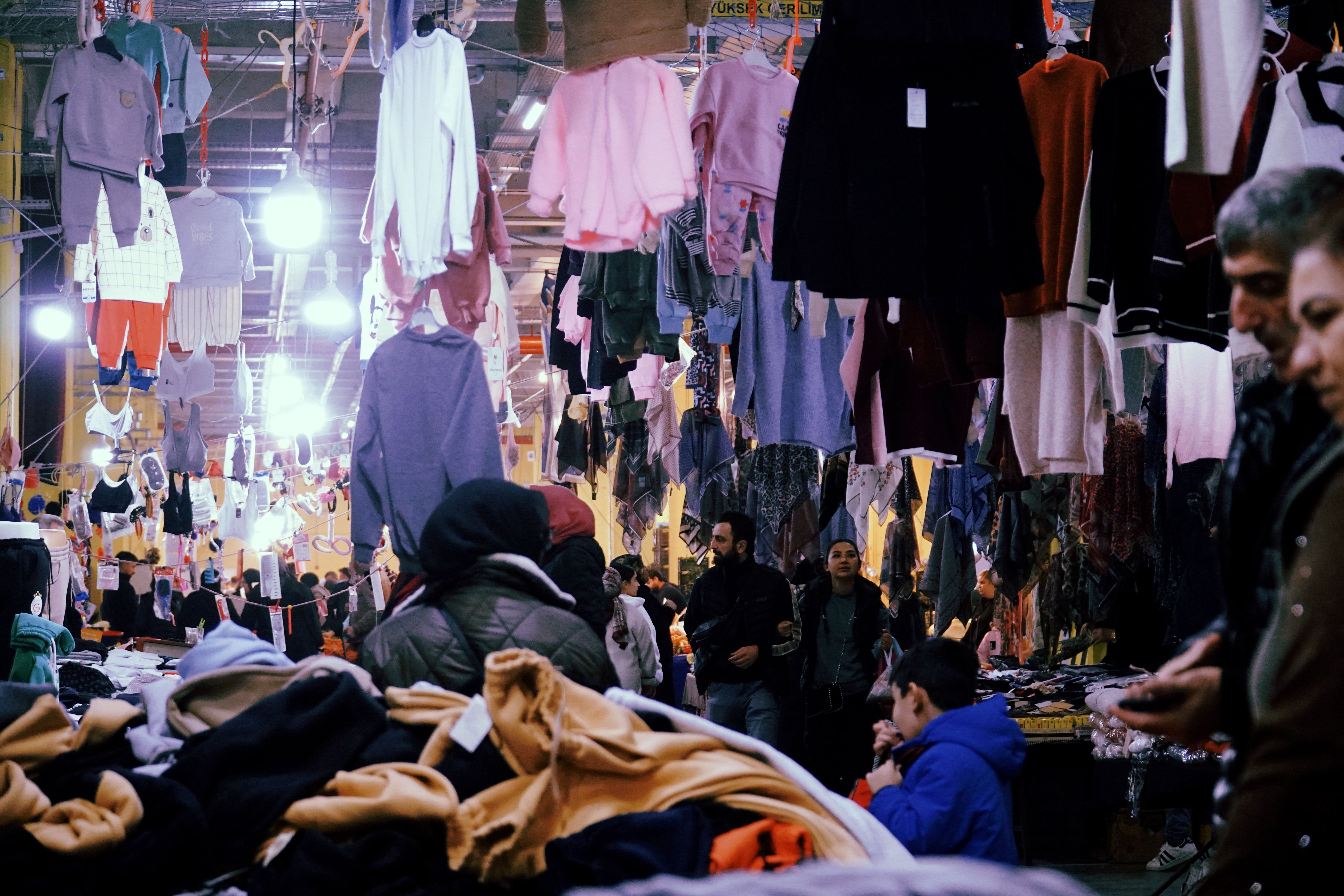 Bustling Indoor Market with Hanging Clothes Display · Free Stock Photo