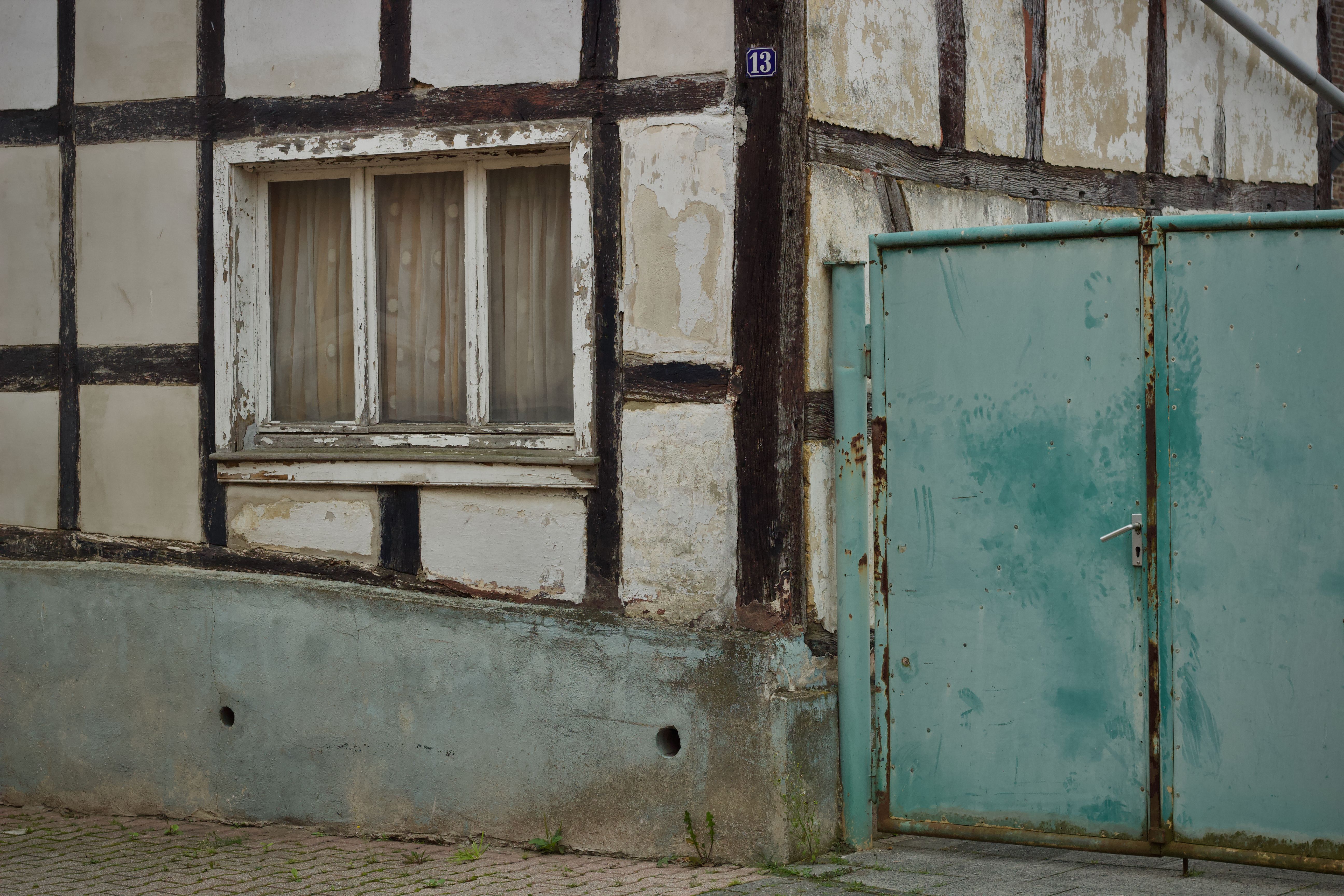 Rustic Half-Timbered House Facade with Weathered Gate · Free Stock Photo