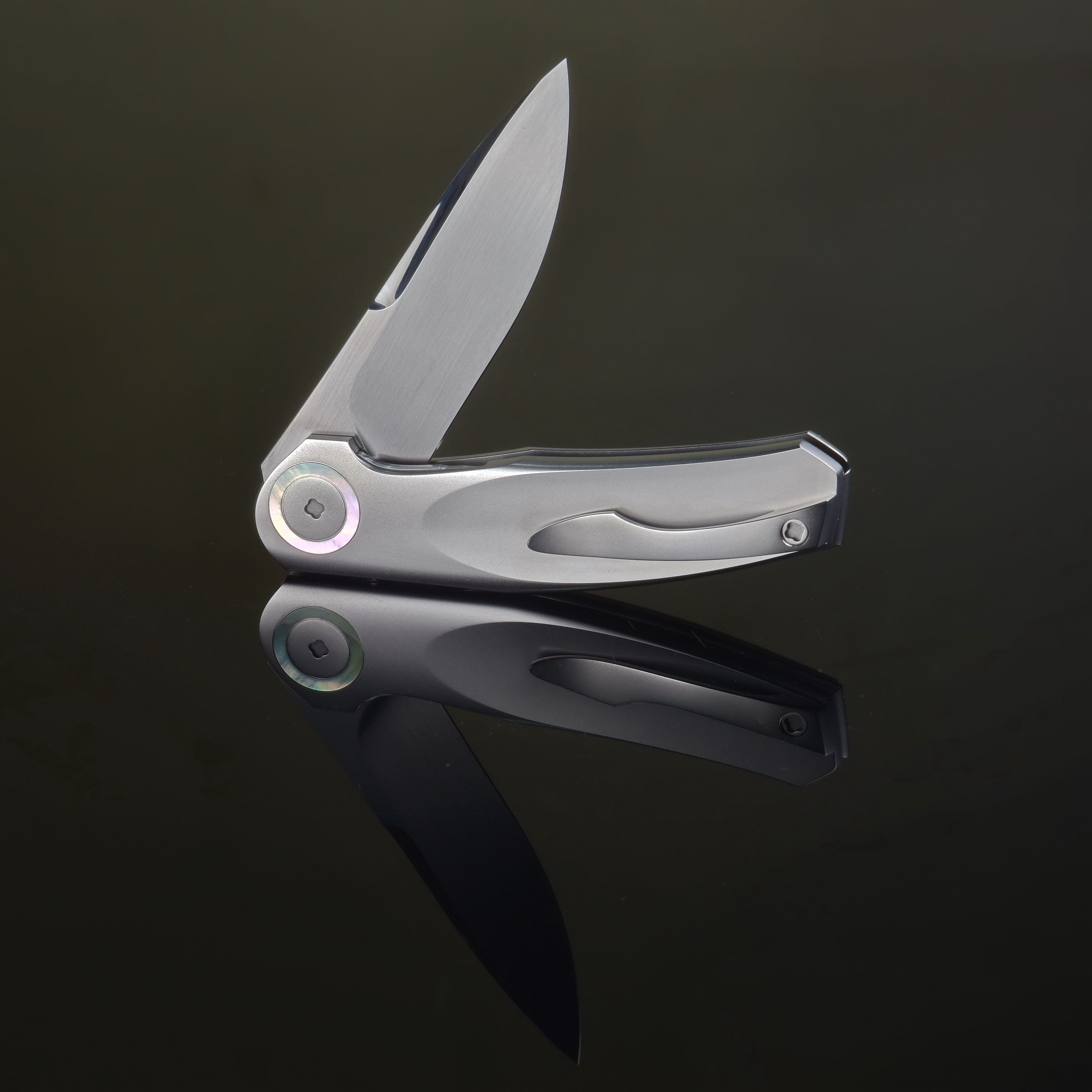 Sleek Folding Knife with Metal Handle Reflection · Free Stock Photo