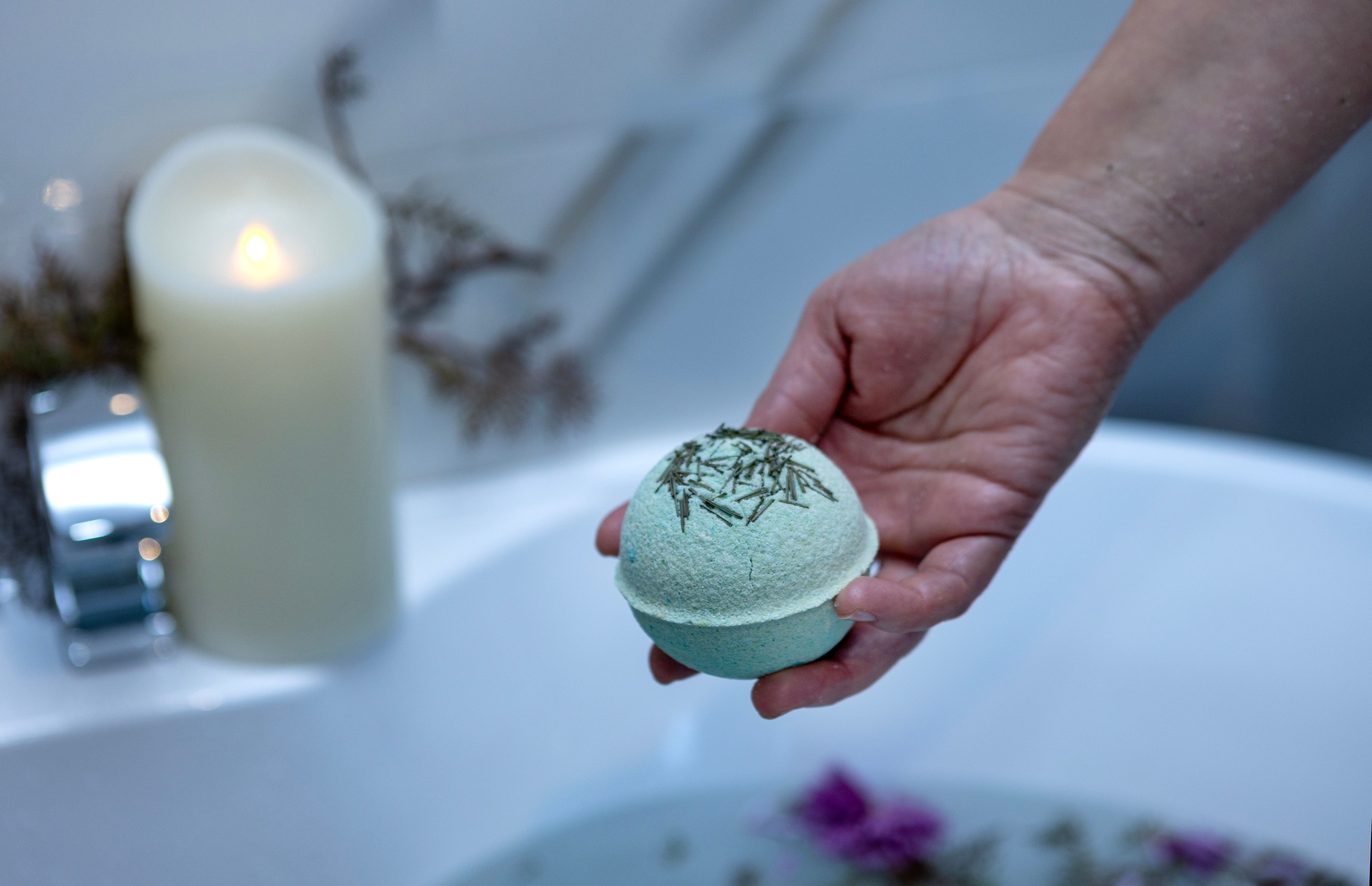 Relaxing Bath Bomb with Candle in Hand · Free Stock Photo
